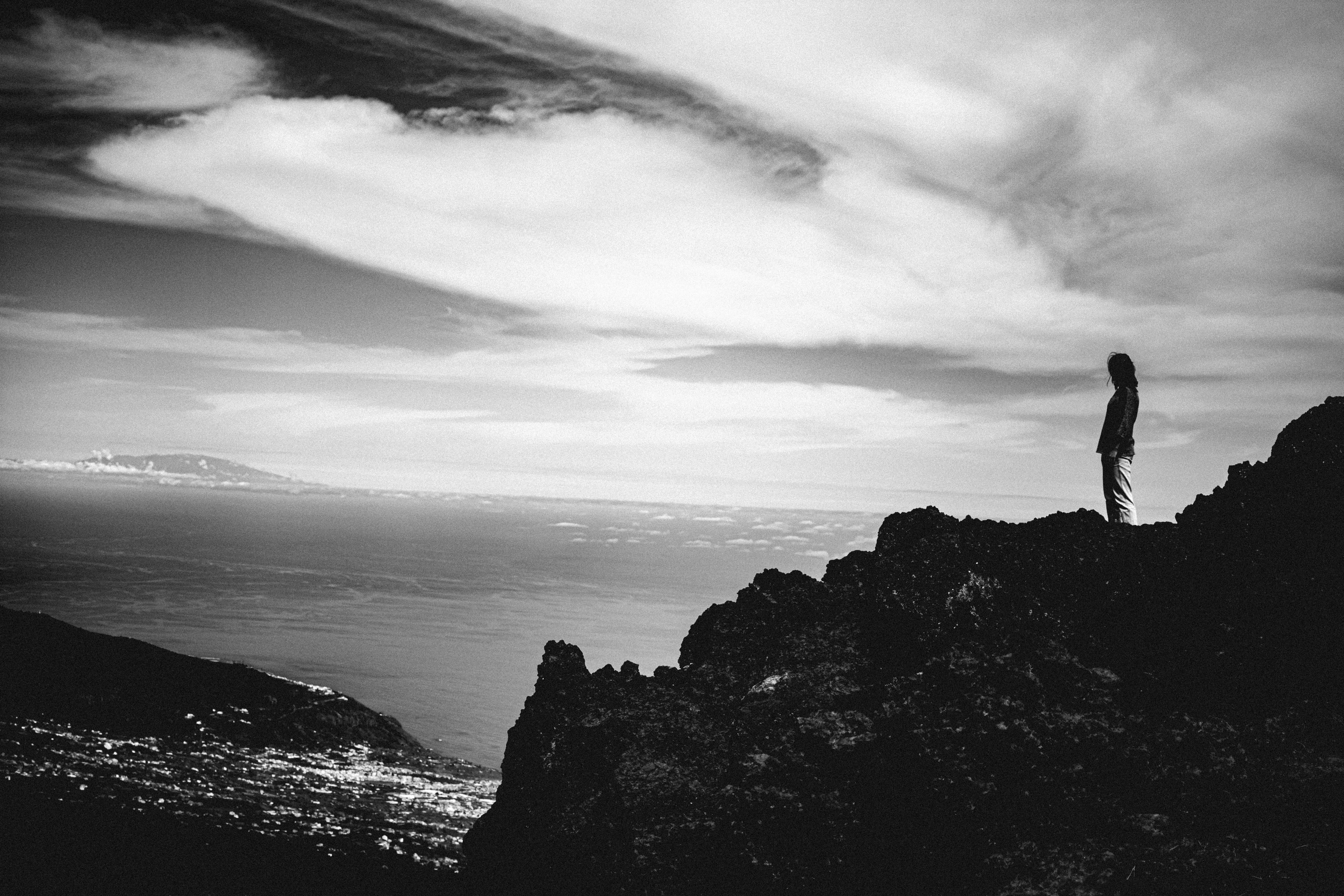 Edge of Quiet: A Lone Figure on a Rugged Coastal Cliff Above the Sea