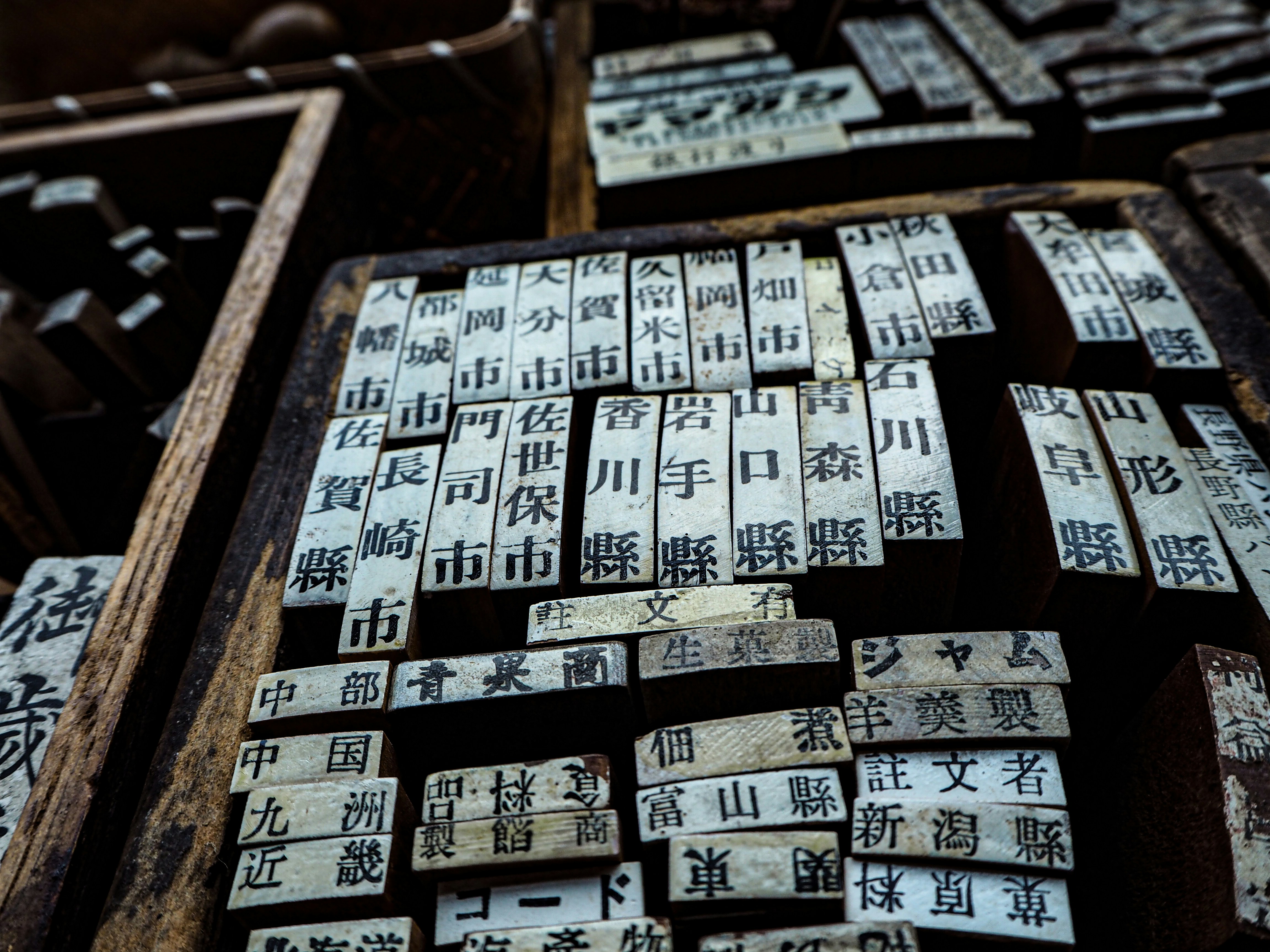 A close-up view of an array of wooden printing blocks featuring intricate characters and symbols, showcasing the craftsmanship of traditional printmaking.