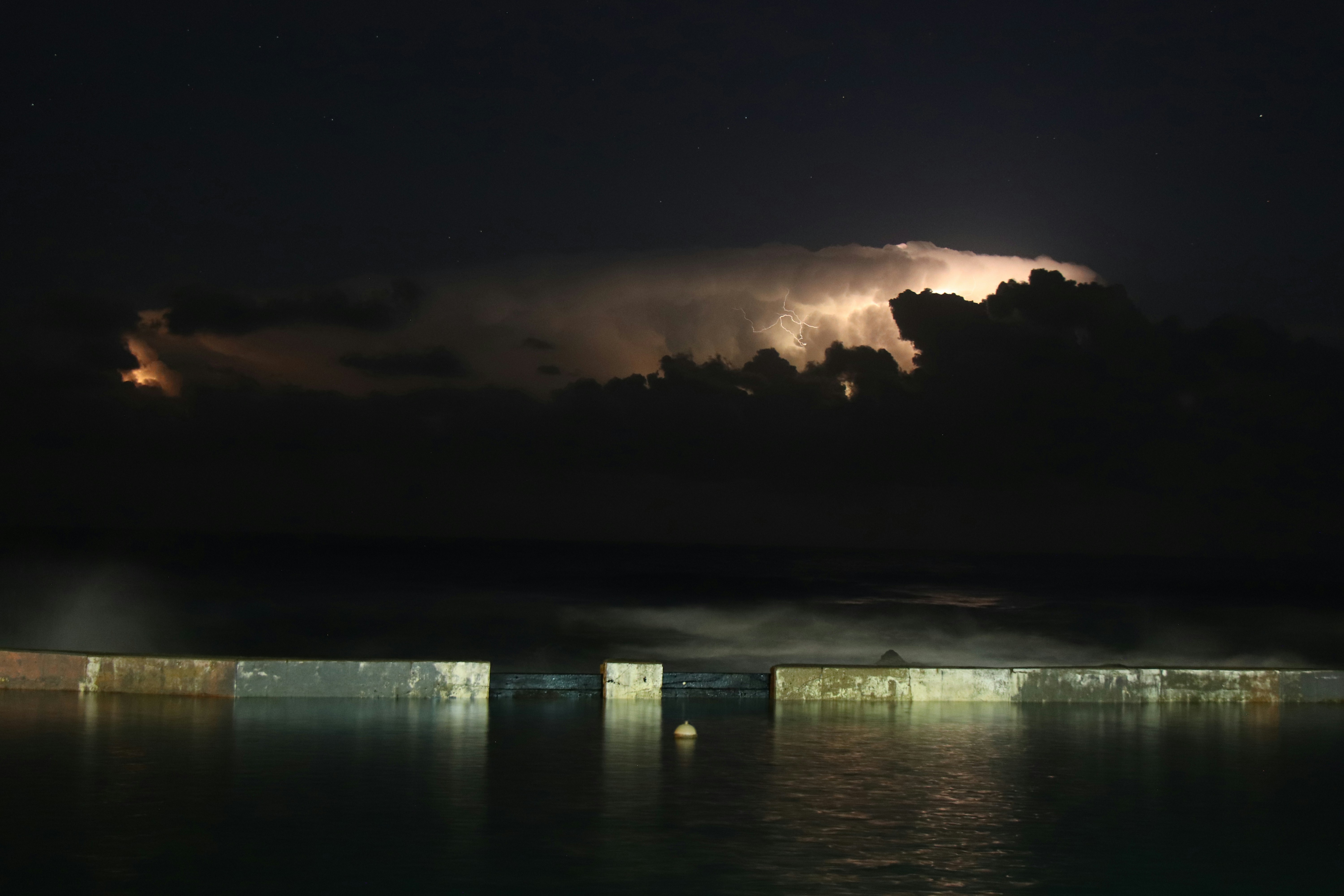 Storm Light Over a Pier: Reflections on a Glassy Sea