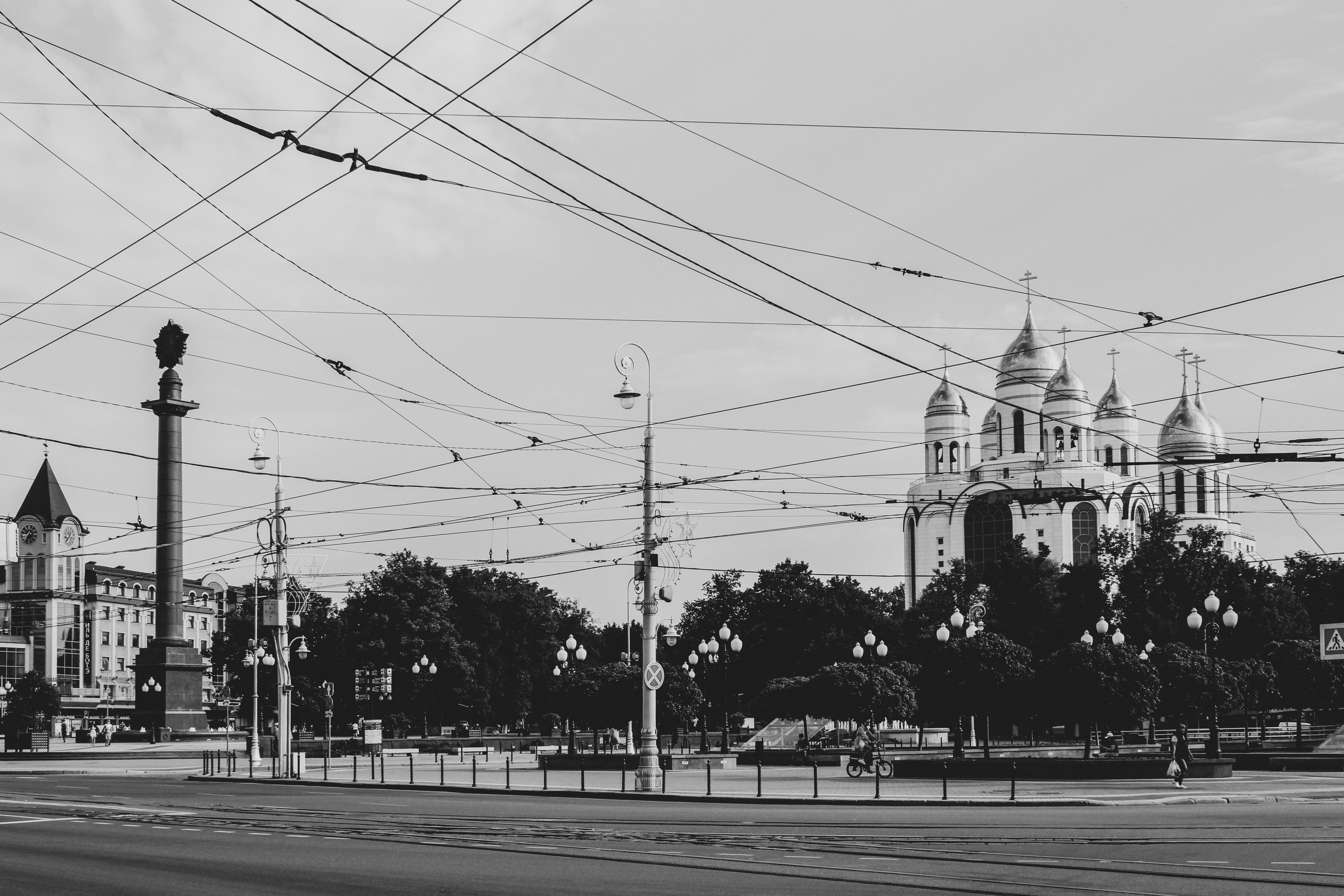 Grayscale cityscape with a cathedral and intersecting tram wires.