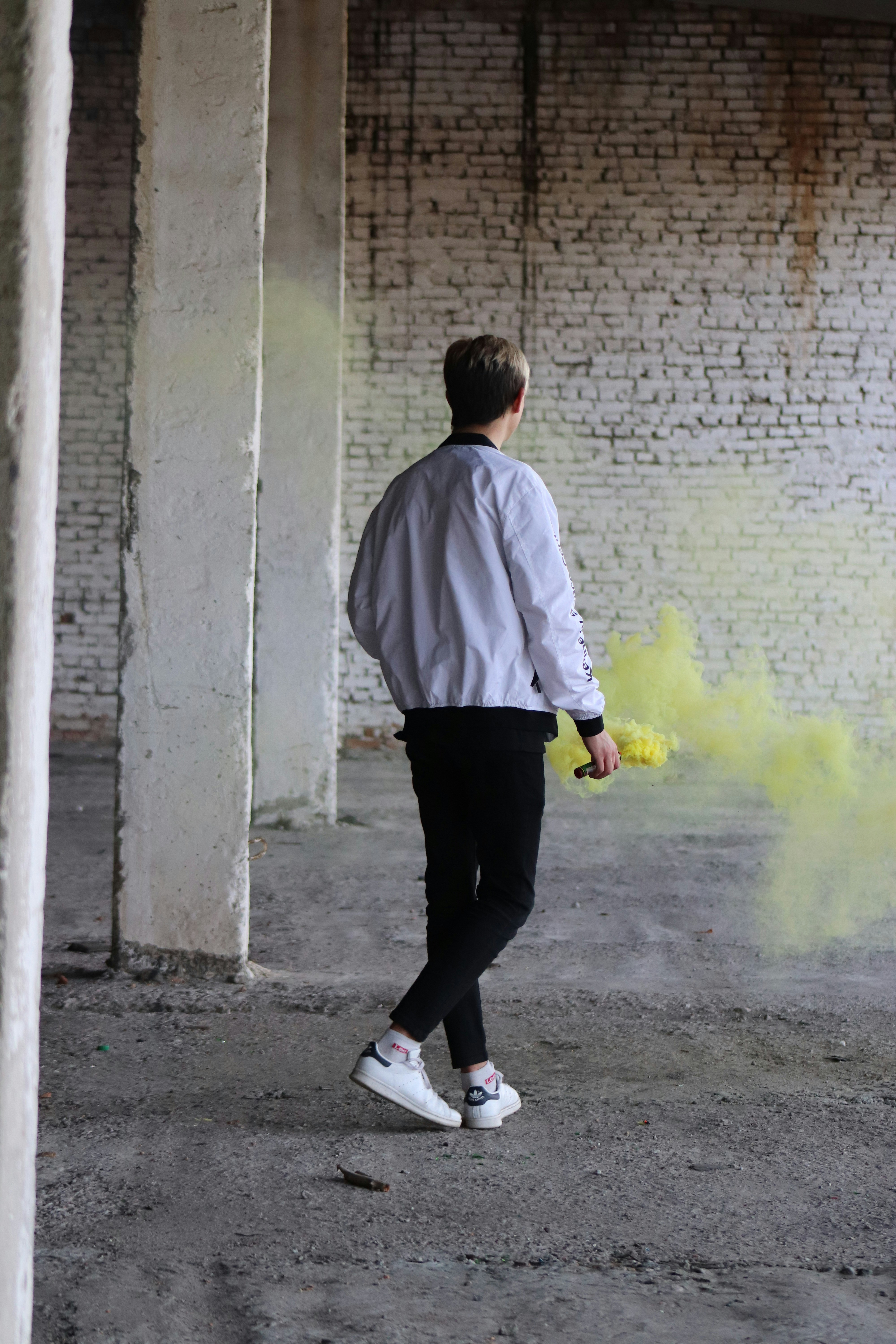 Back-turned in a Yellow Cloud: A Lone Figure in a Crumbling Warehouse