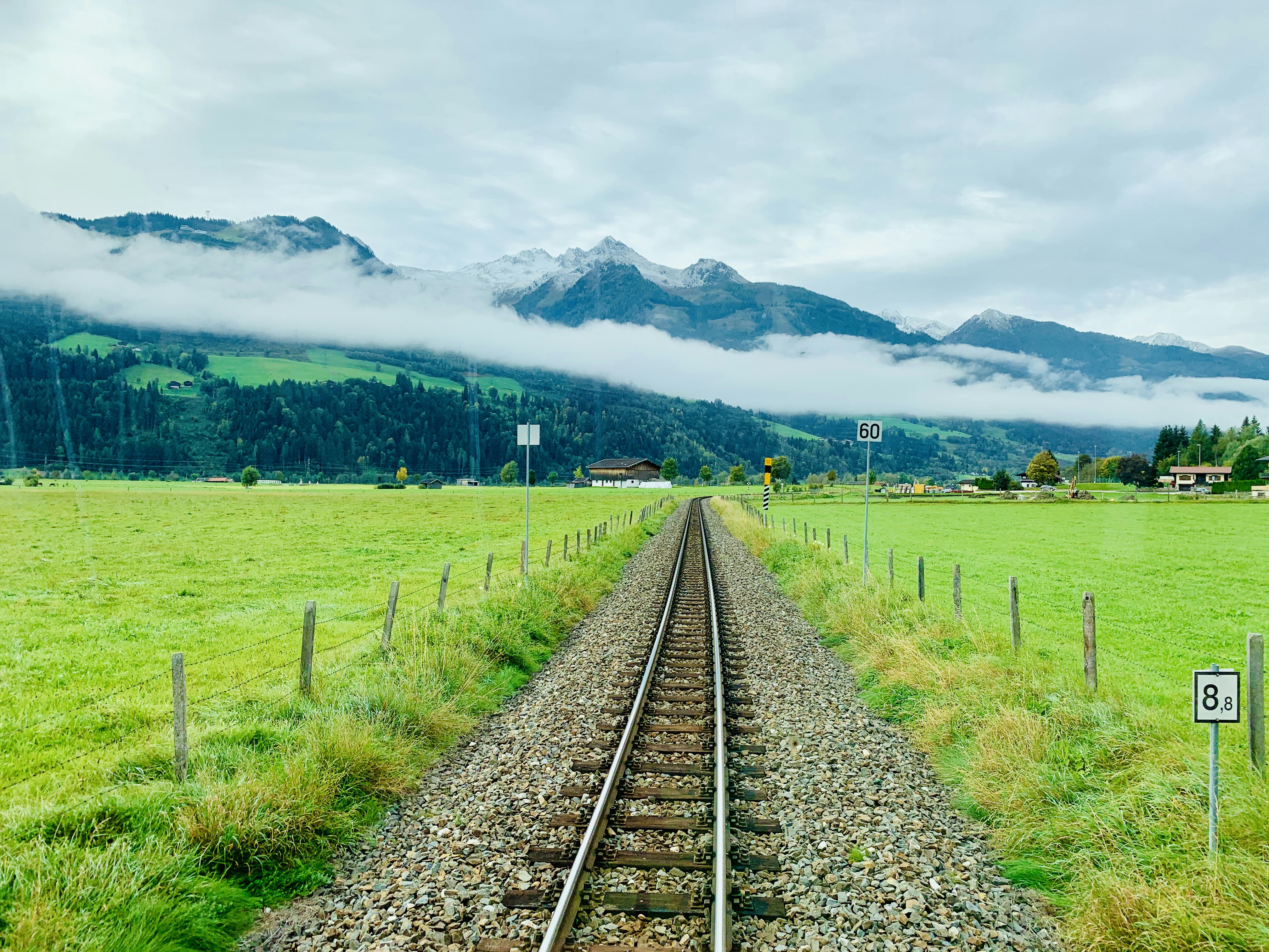 Rails Toward the Alpine Horizon: A Straight Path Through Emerald Valleys to Misty Peaks