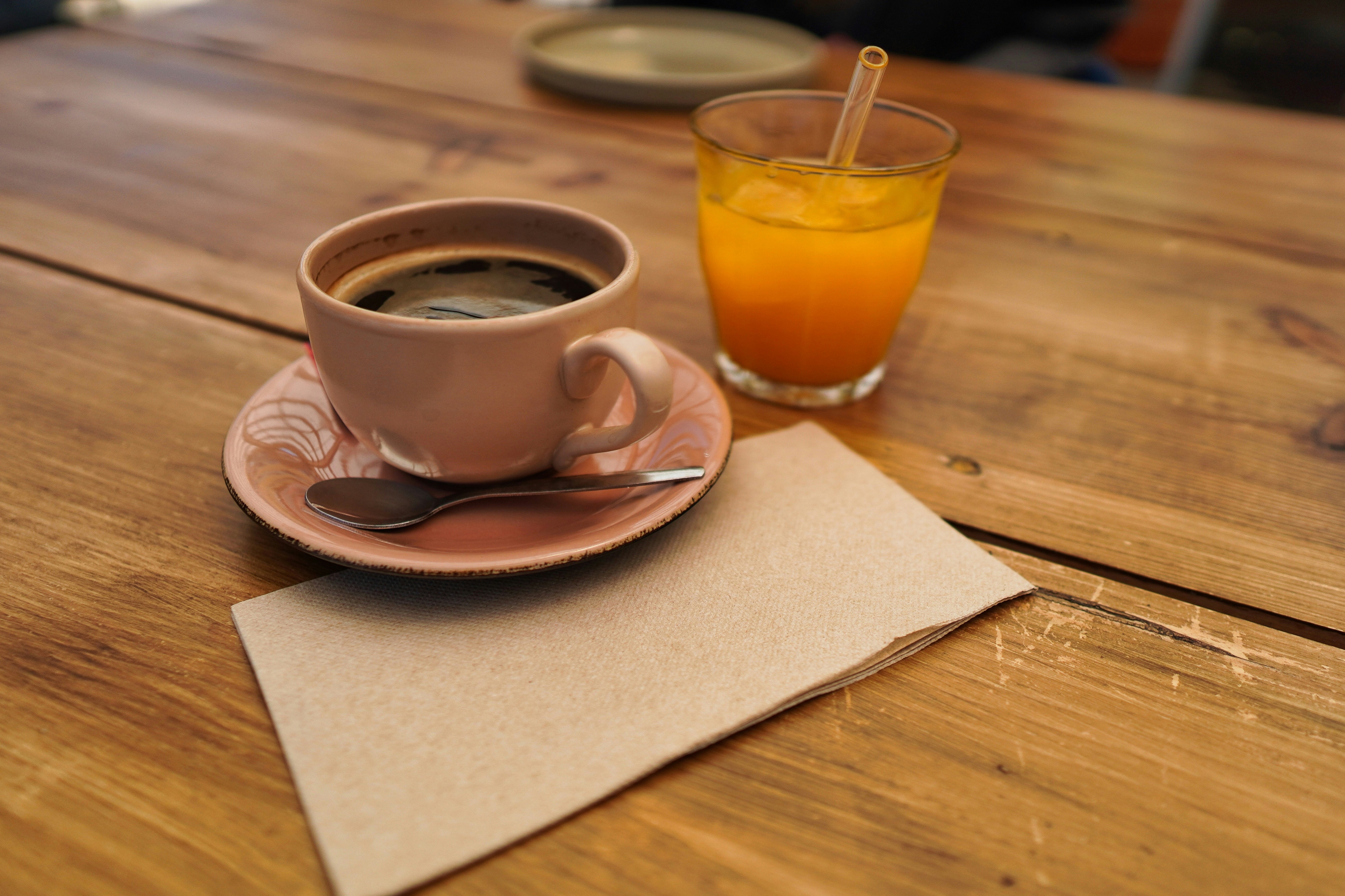 Morning Ritual on Weathered Wood: A Coffee Cup and a Glass of Orange Juice