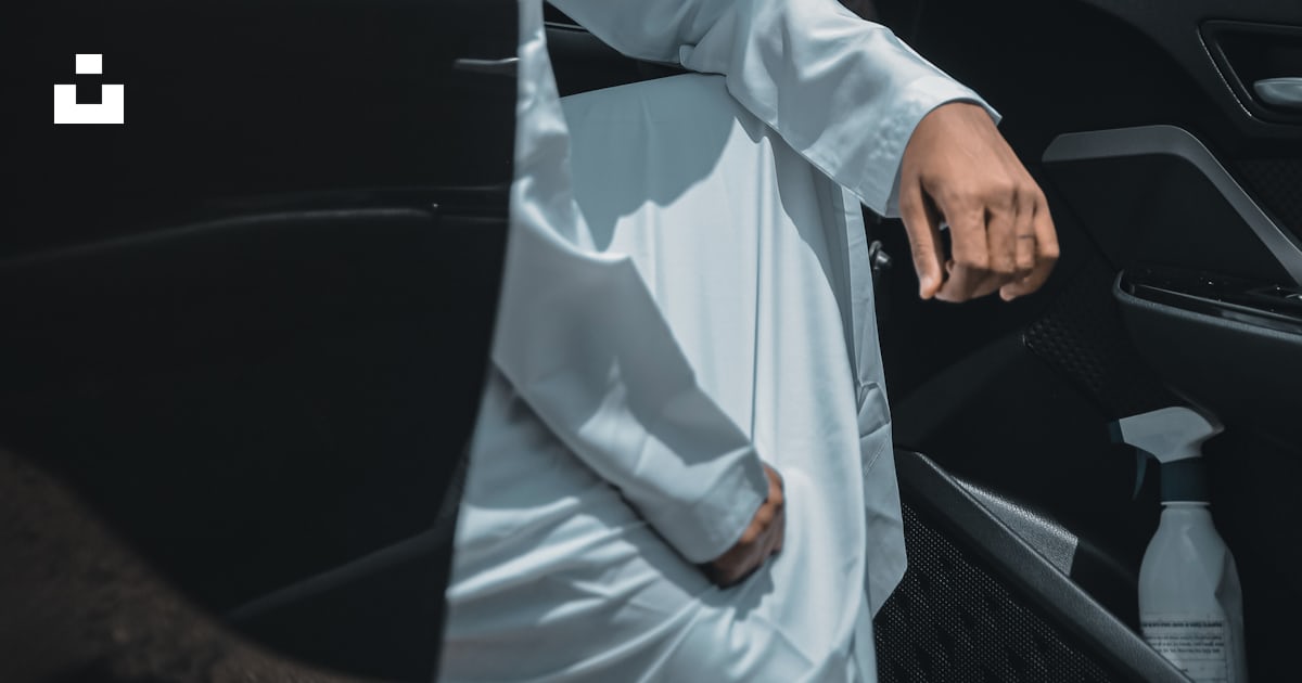 昼間、黒い車の脇に立つ白いトーブを着た男の写真 Unsplashの人間の無料画像