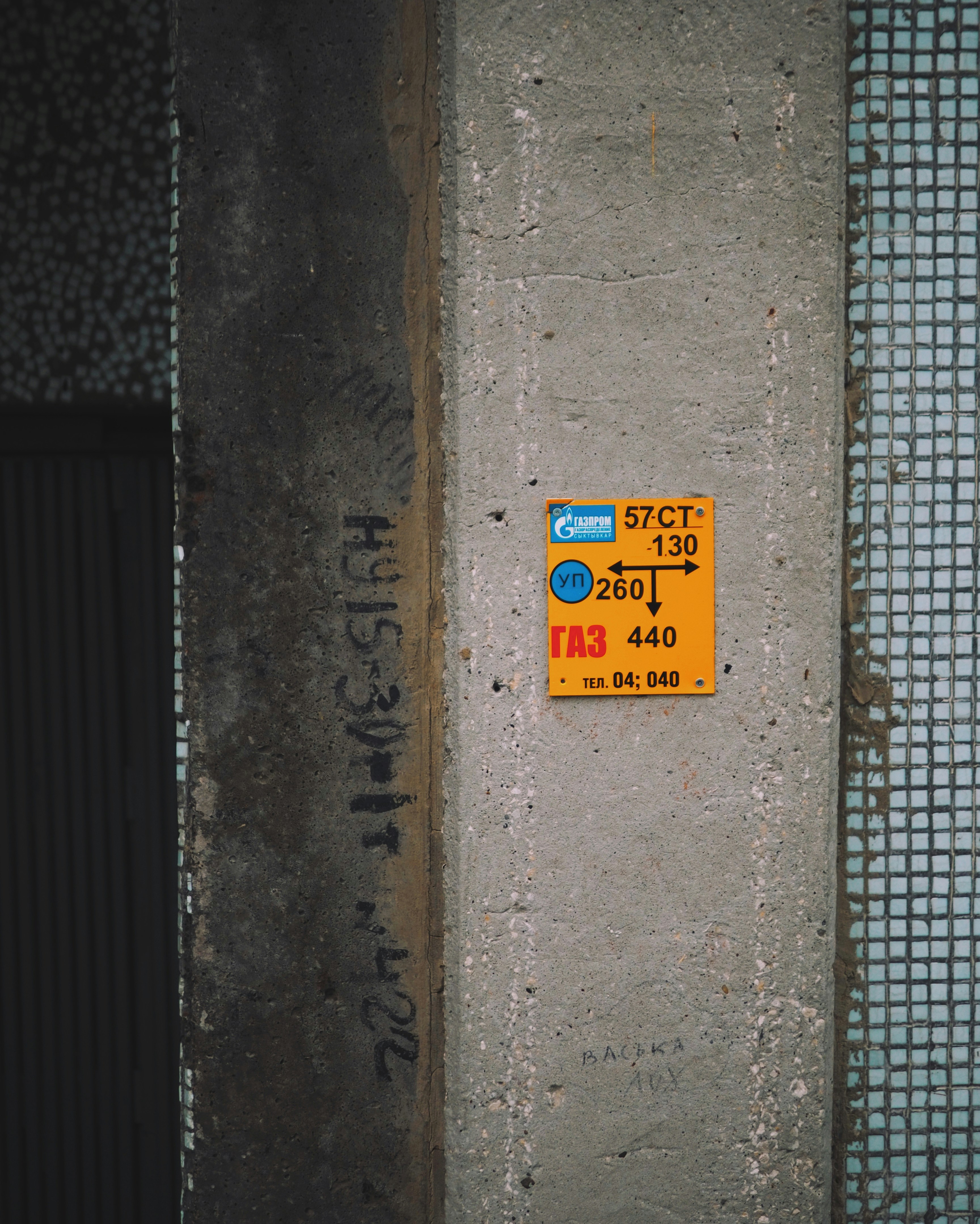 A yellow and blue sign on the side of a building photo – Free Wall ...