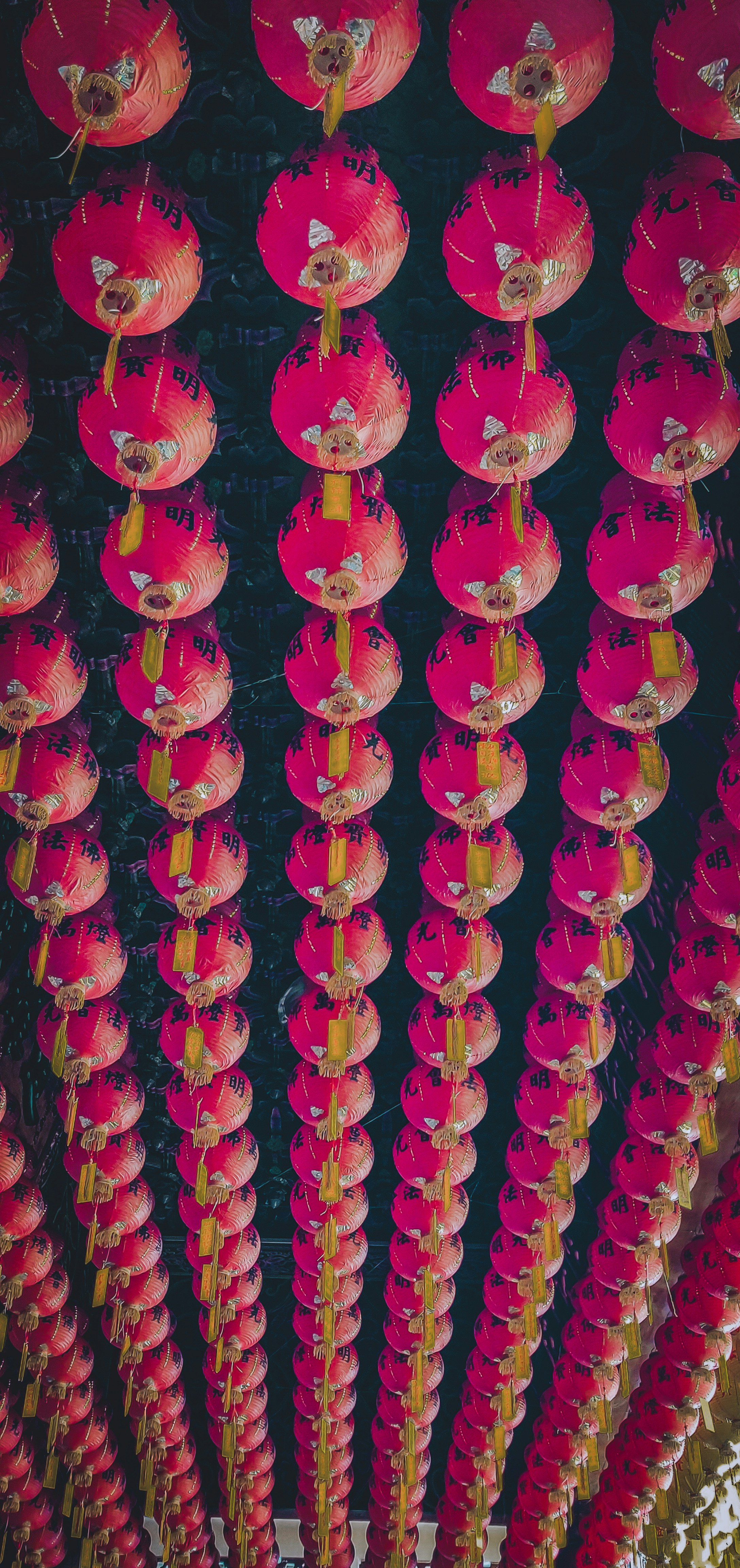Vibrant red lanterns suspended in a symmetrical arrangement, creating a striking visual display against a dark backdrop.