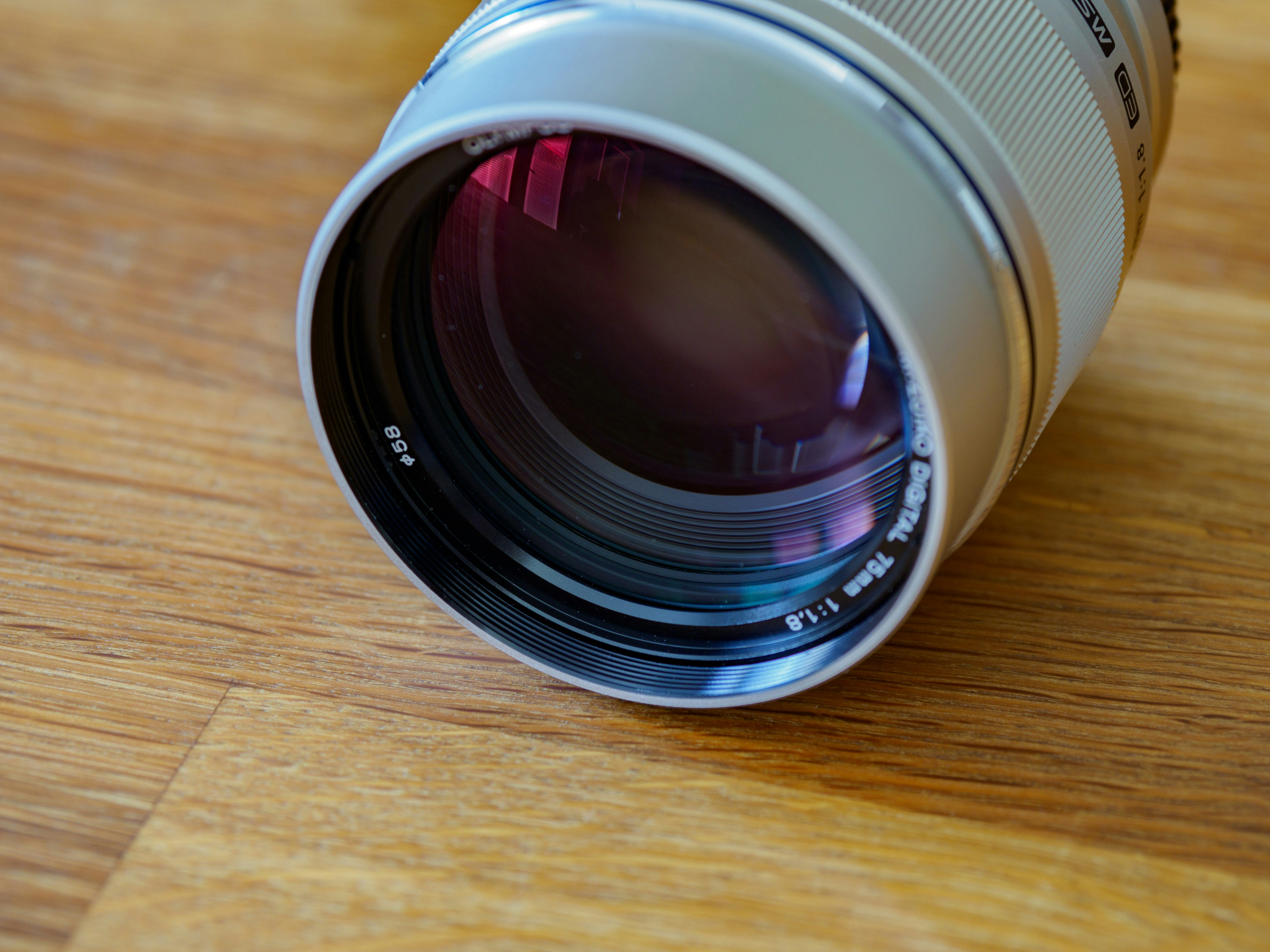 A camera lens sitting on top of a wooden table photo – Free Electronics ...