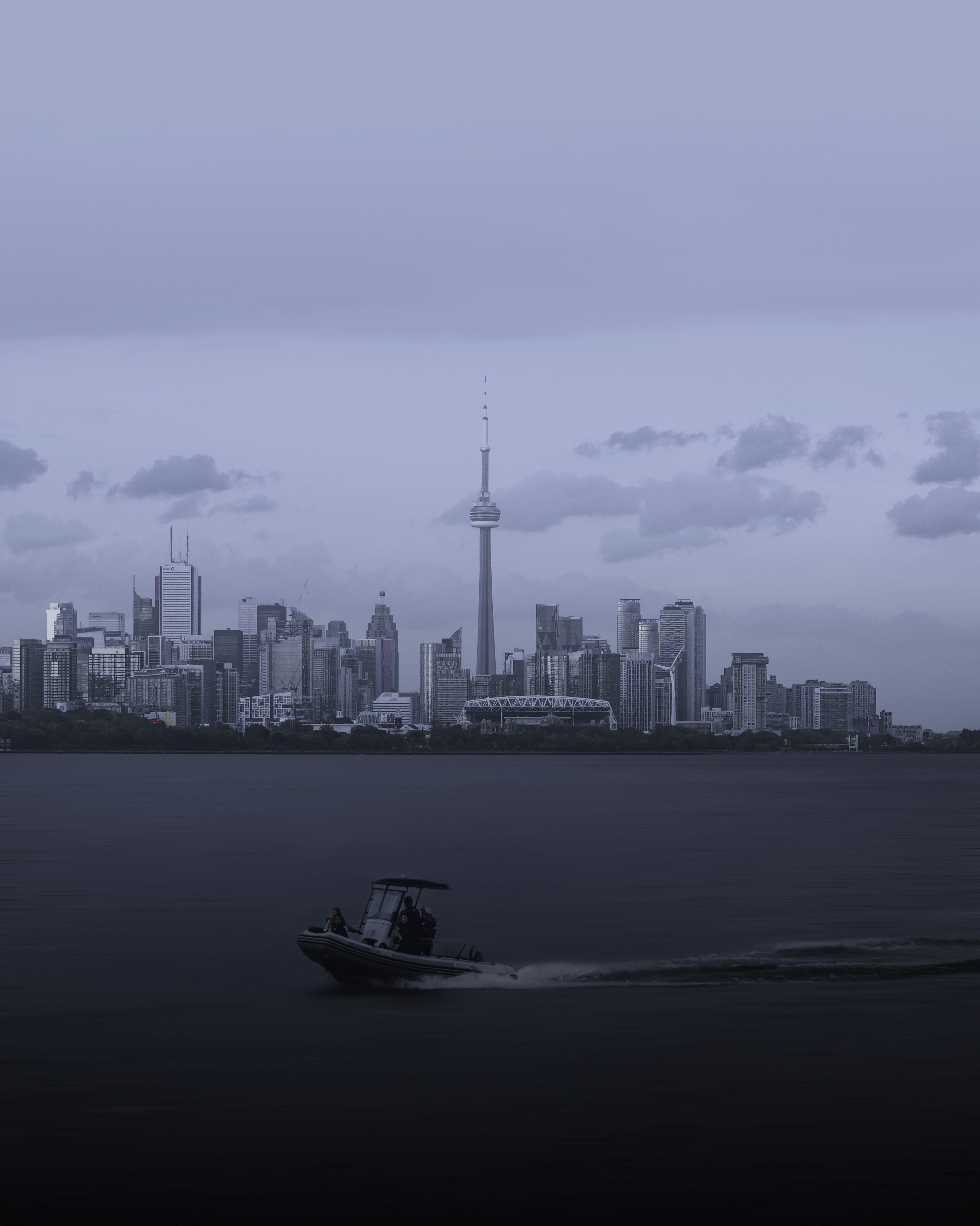 Blue Hour Over Toronto: A Boat Skims the Harbor Beneath the Glass Skyline