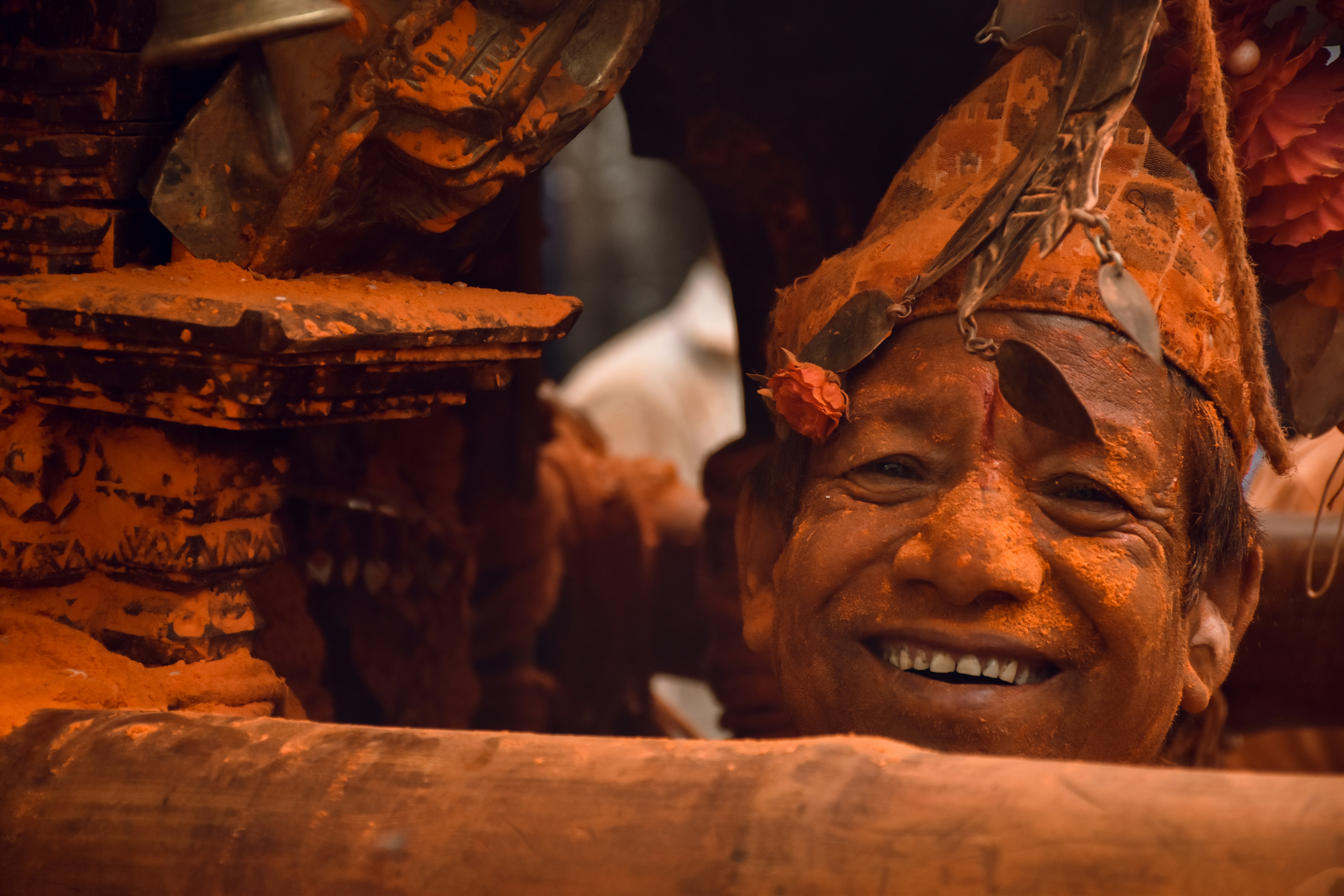 Smiles in Turmeric Light: A Festival Moment Peering Through Carved Wood