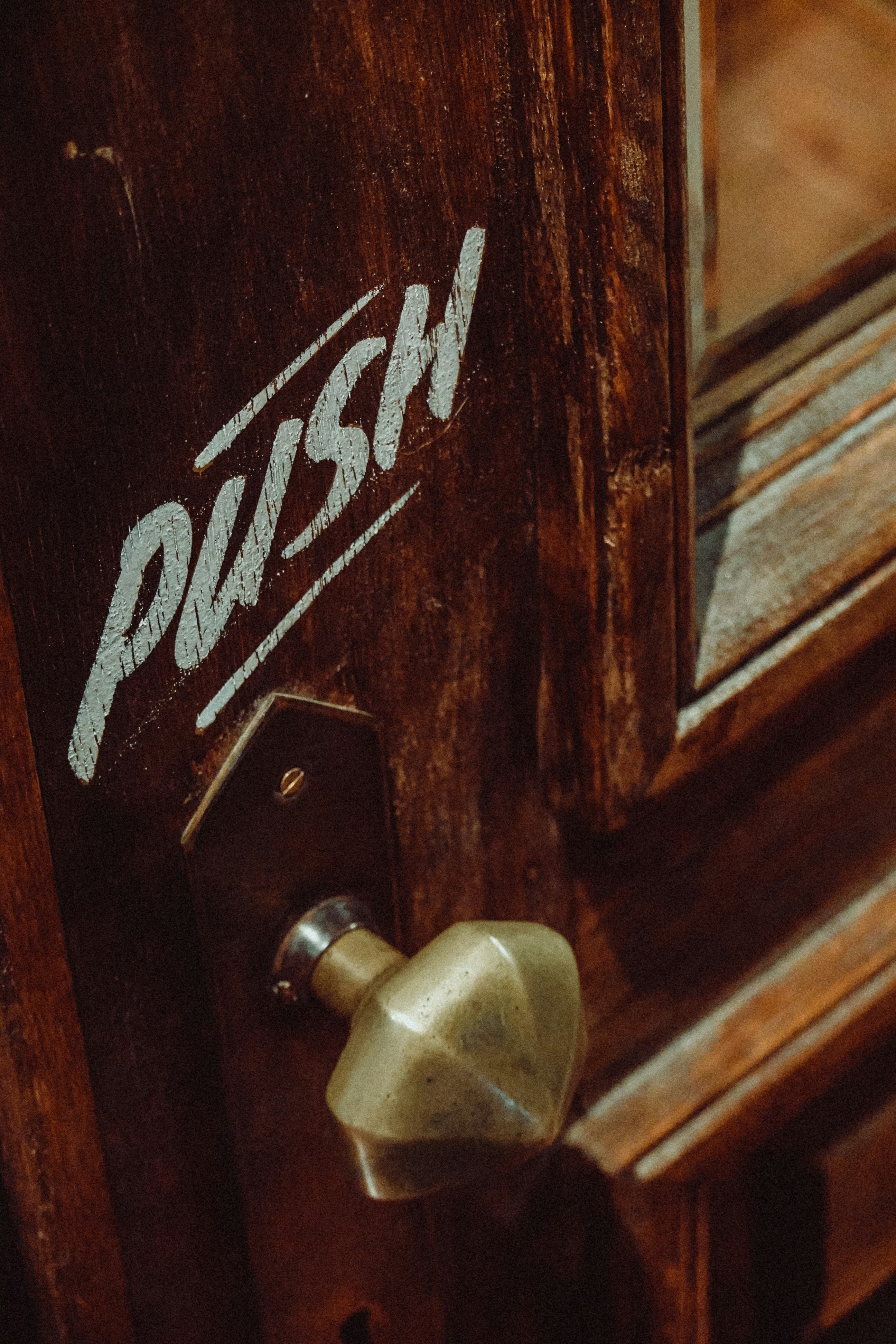 Polished Door Knob: Vintage Wood and Script in Focus