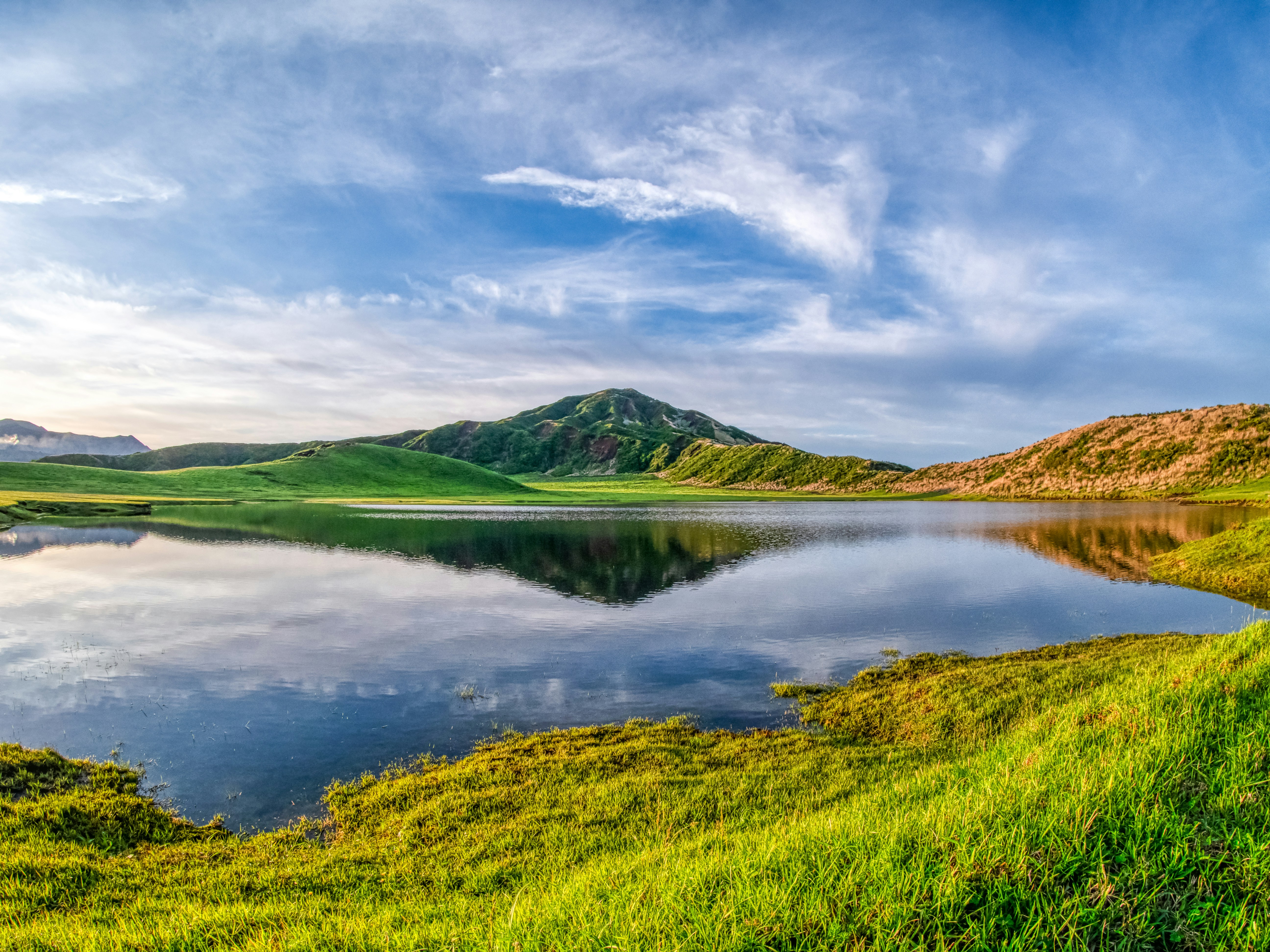 Green grass field near lake under blue sky during daytime photo – Free ...