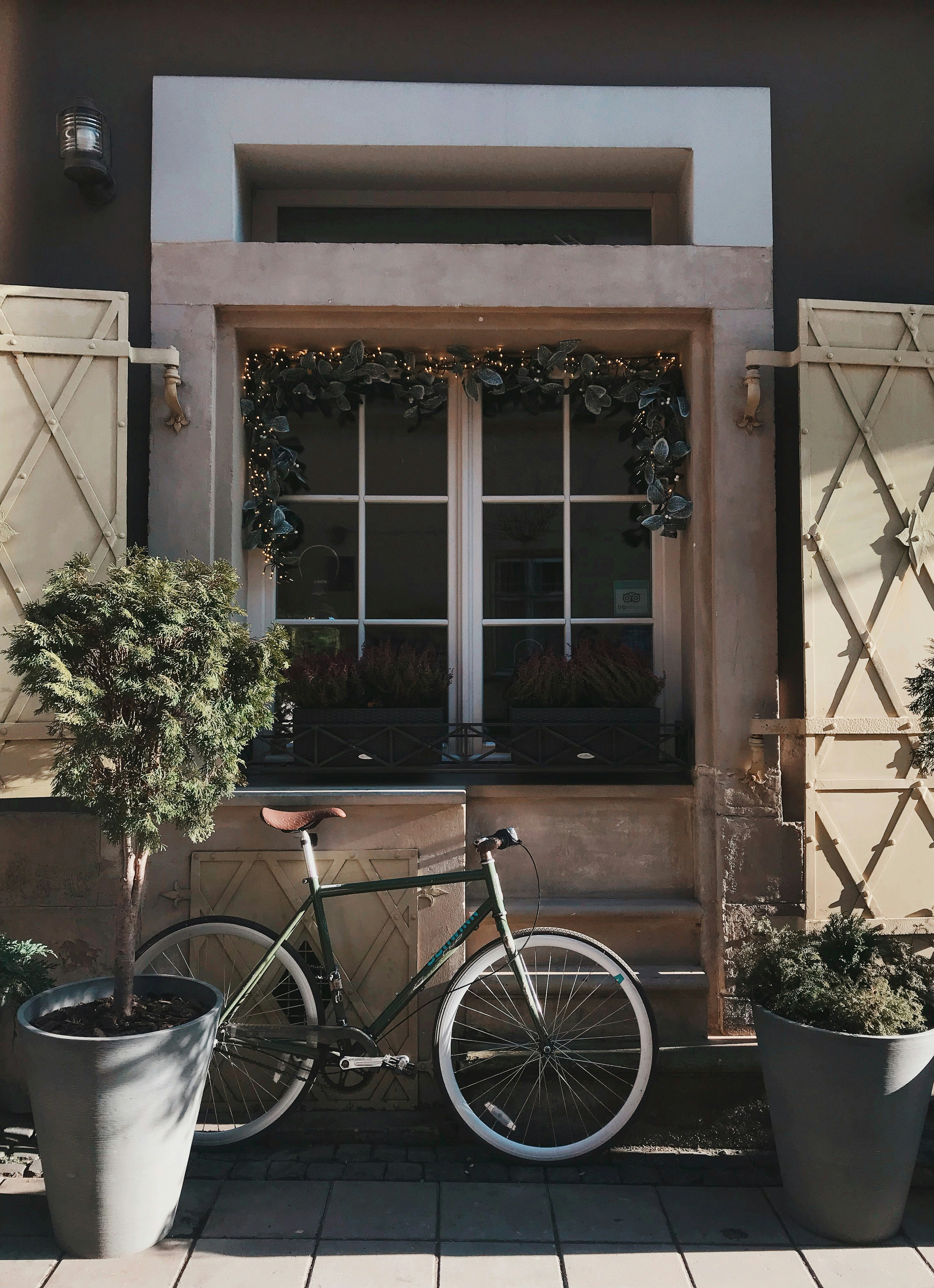 white city bike parked beside brown wooden window photo – Free Wheel ...