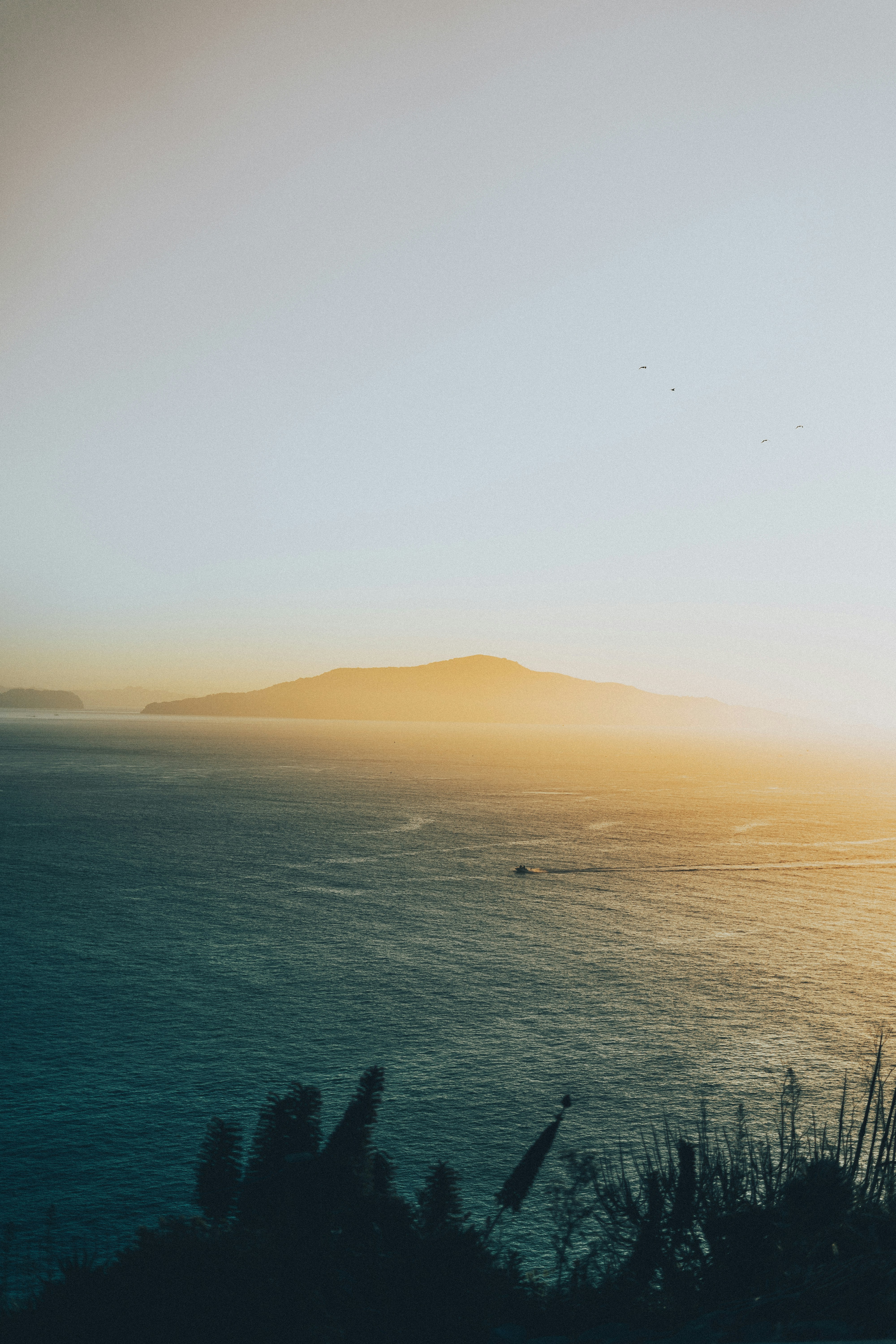 body of water near mountain during daytime
