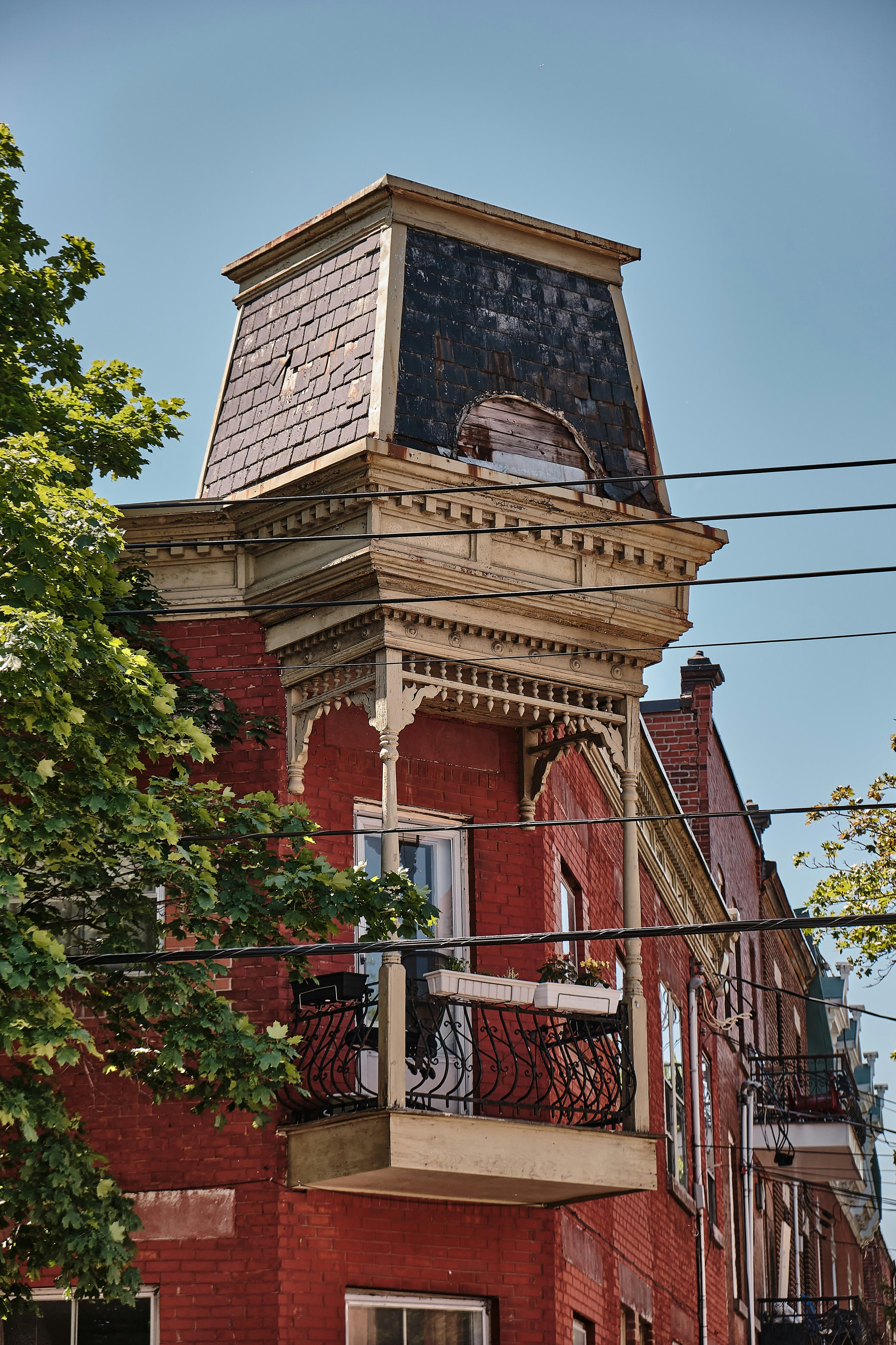 Brick Facade with Ornate Balcony and Slate-Top Tower