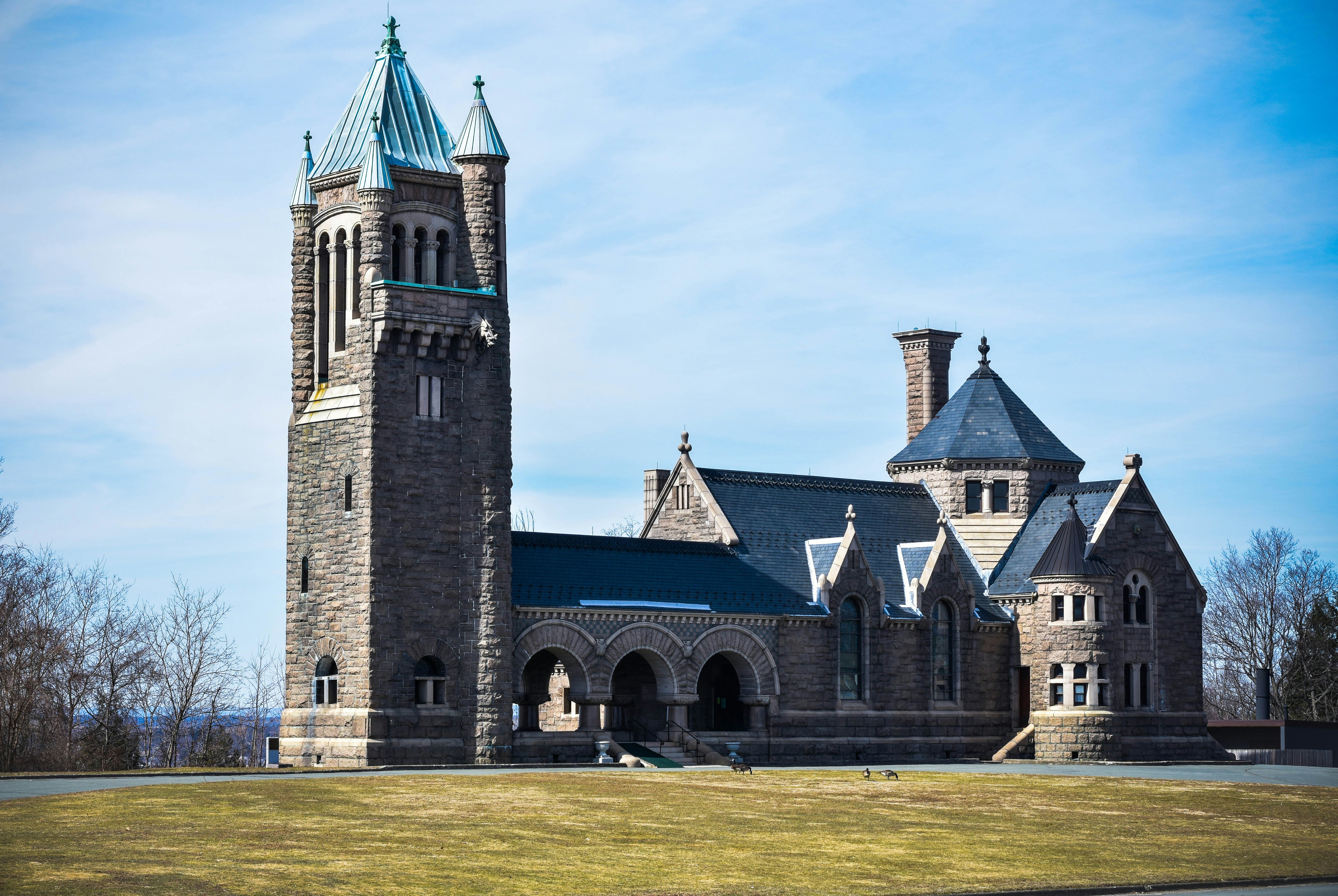 Ornate stone building with a tall tower under a clear blue sky.