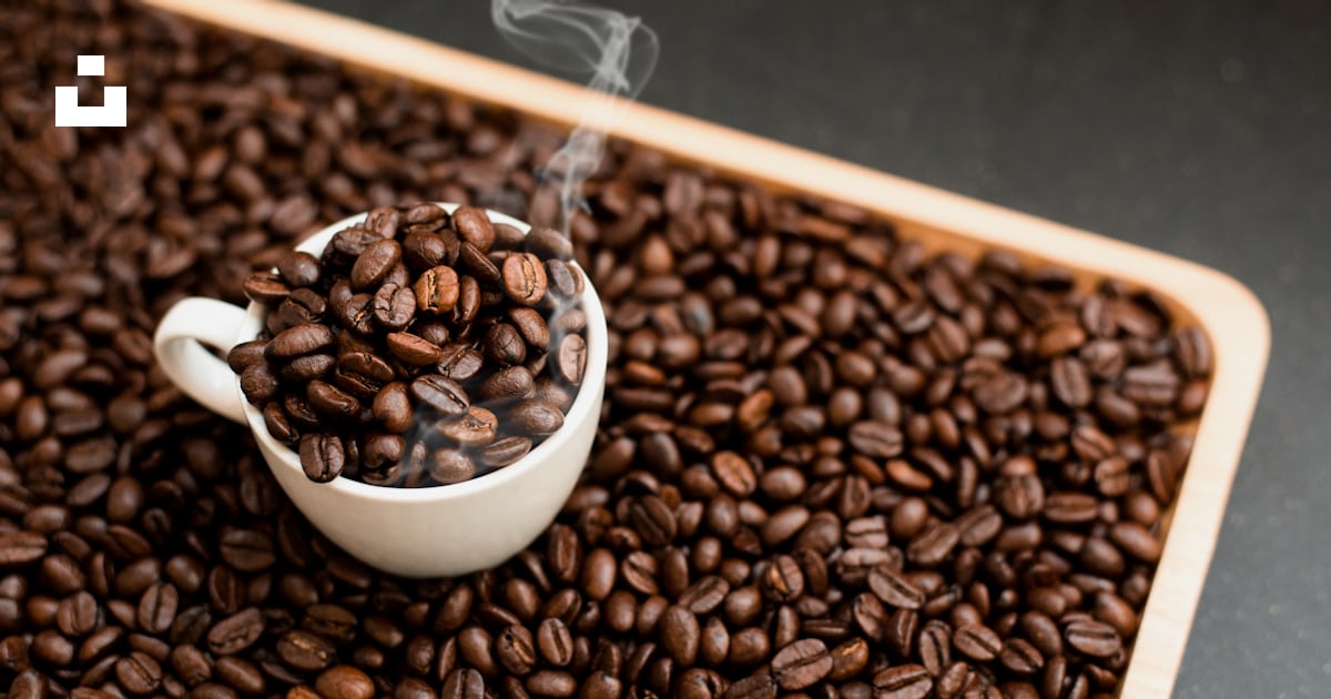 Une Tasse Blanche Remplie De Grains De Café Sur Une Table Photo Photo