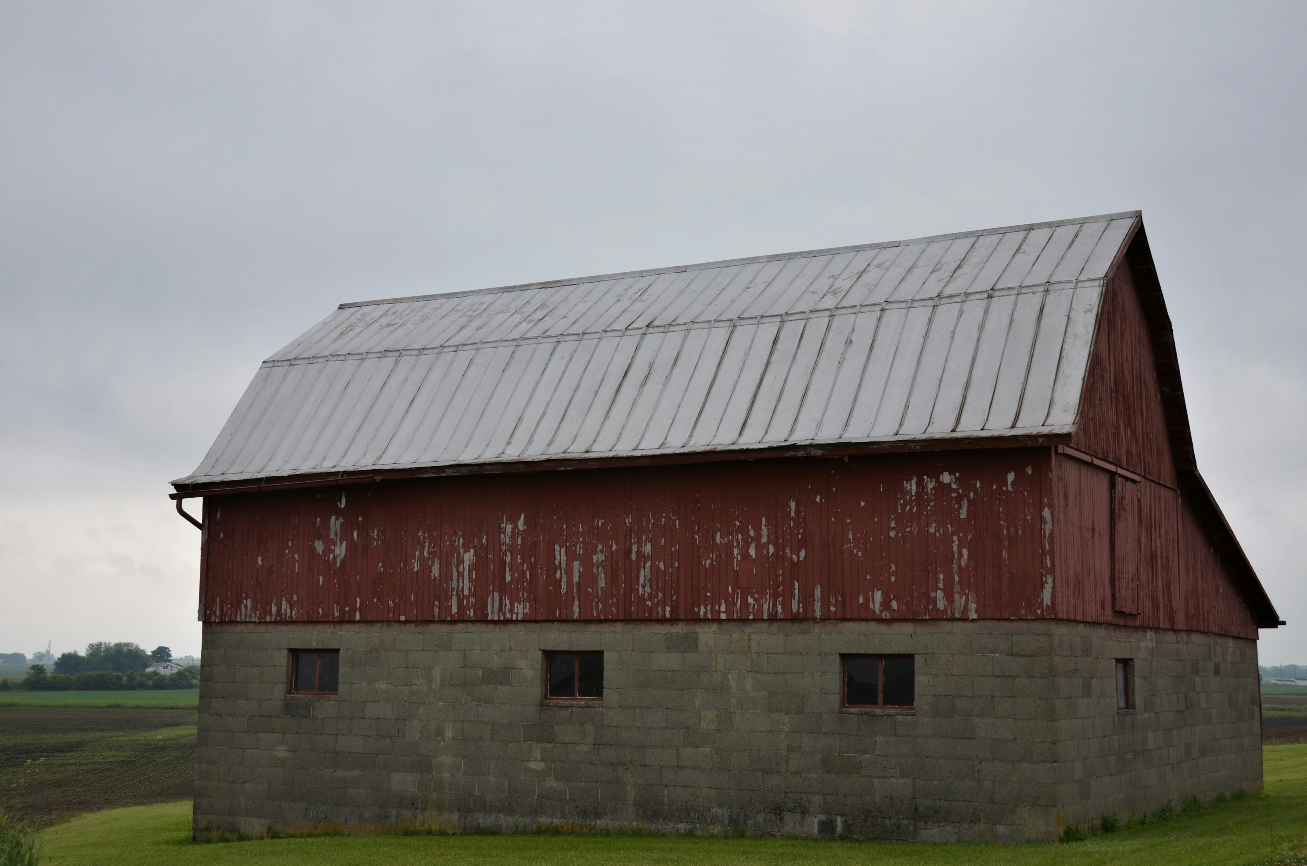 Weathered Red Barn on a Quiet Prairie Beneath a Somber Sky