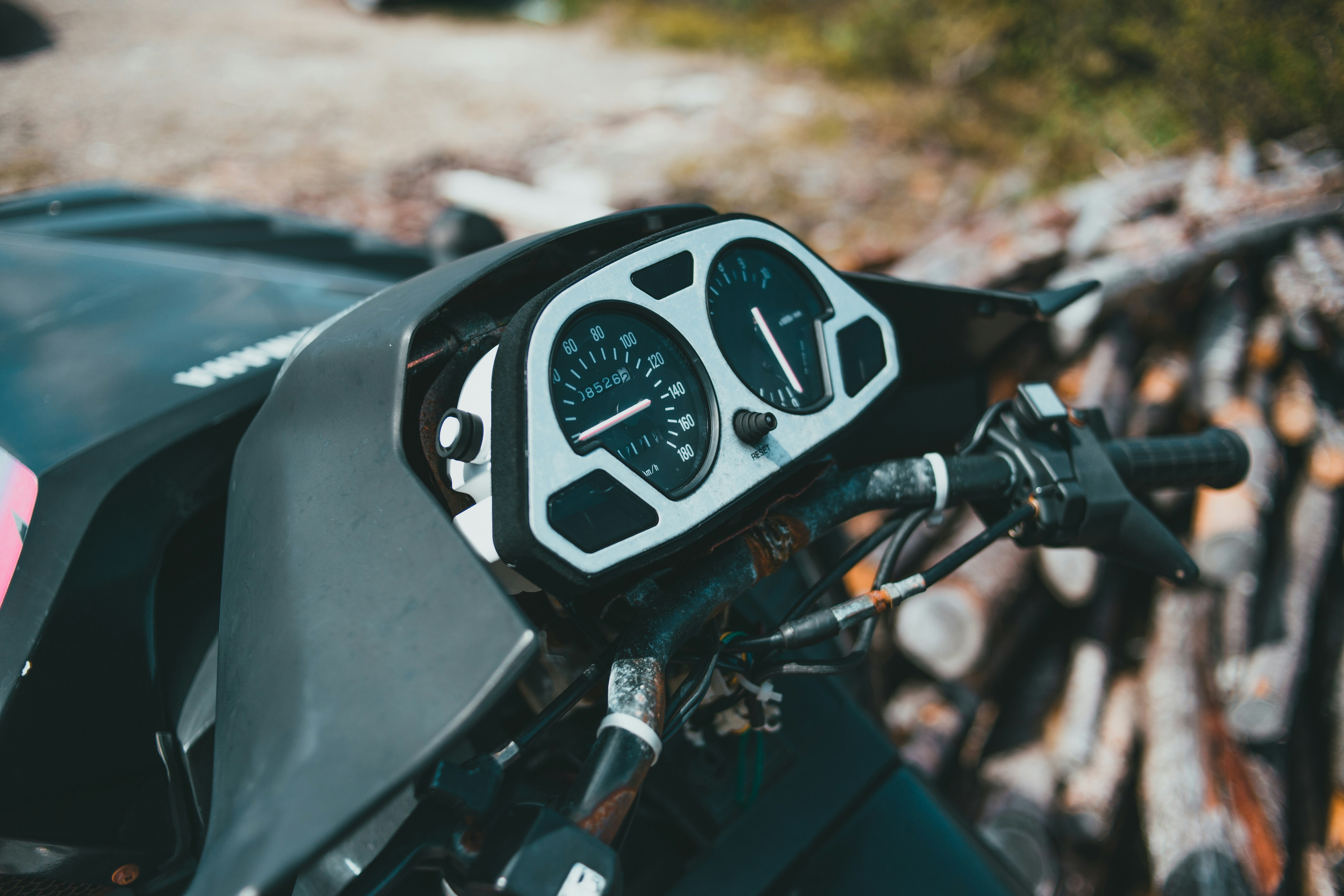 Rusted Reflections: A Close-Up of a Vintage Motorcycle Instrument Cluster