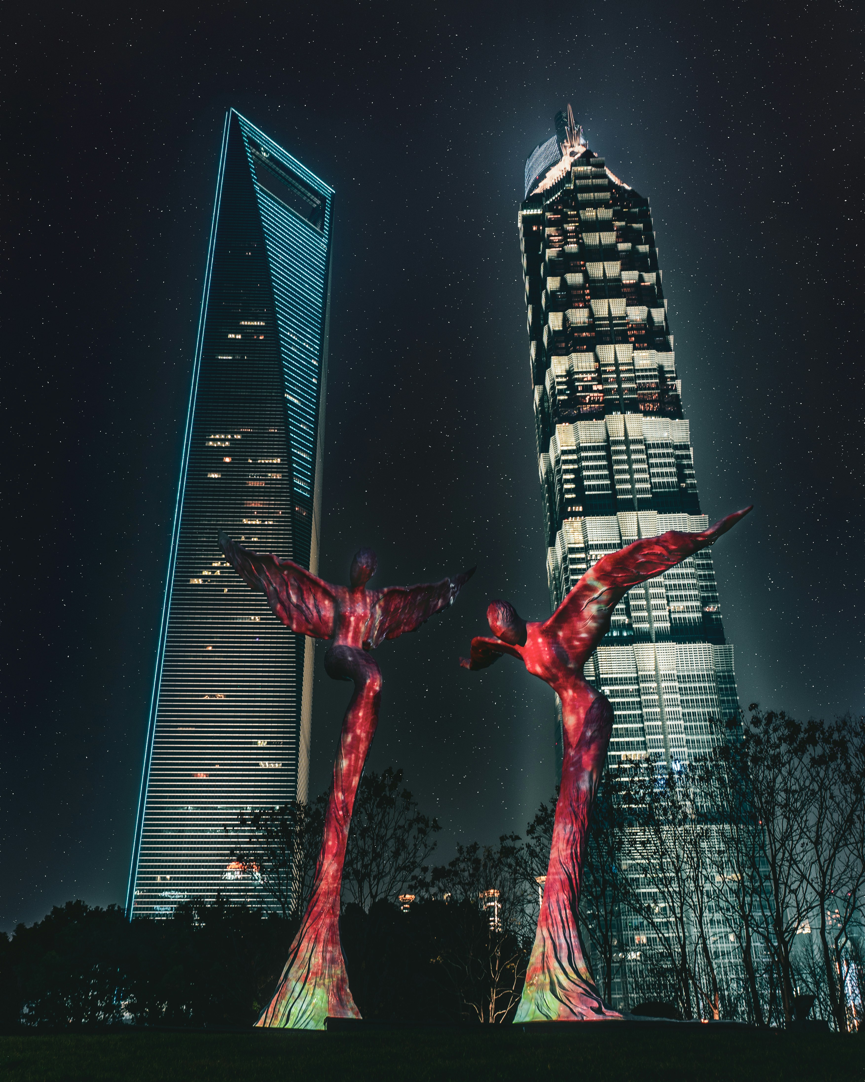 Crimson Bird Sculptures Framing a Starry Night Between Glass Giants