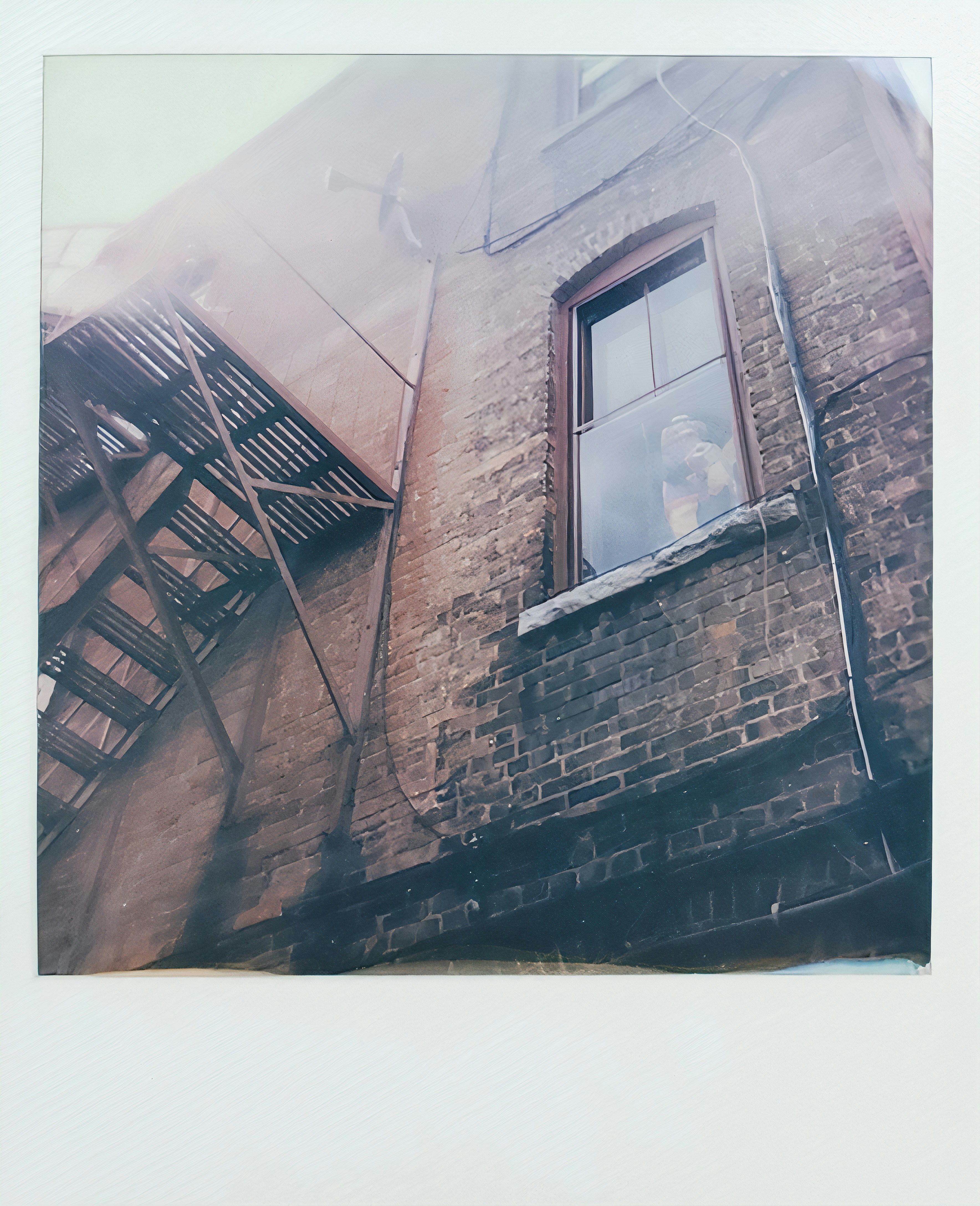 A man looking out of a window of a brick building photo – Free Building ...