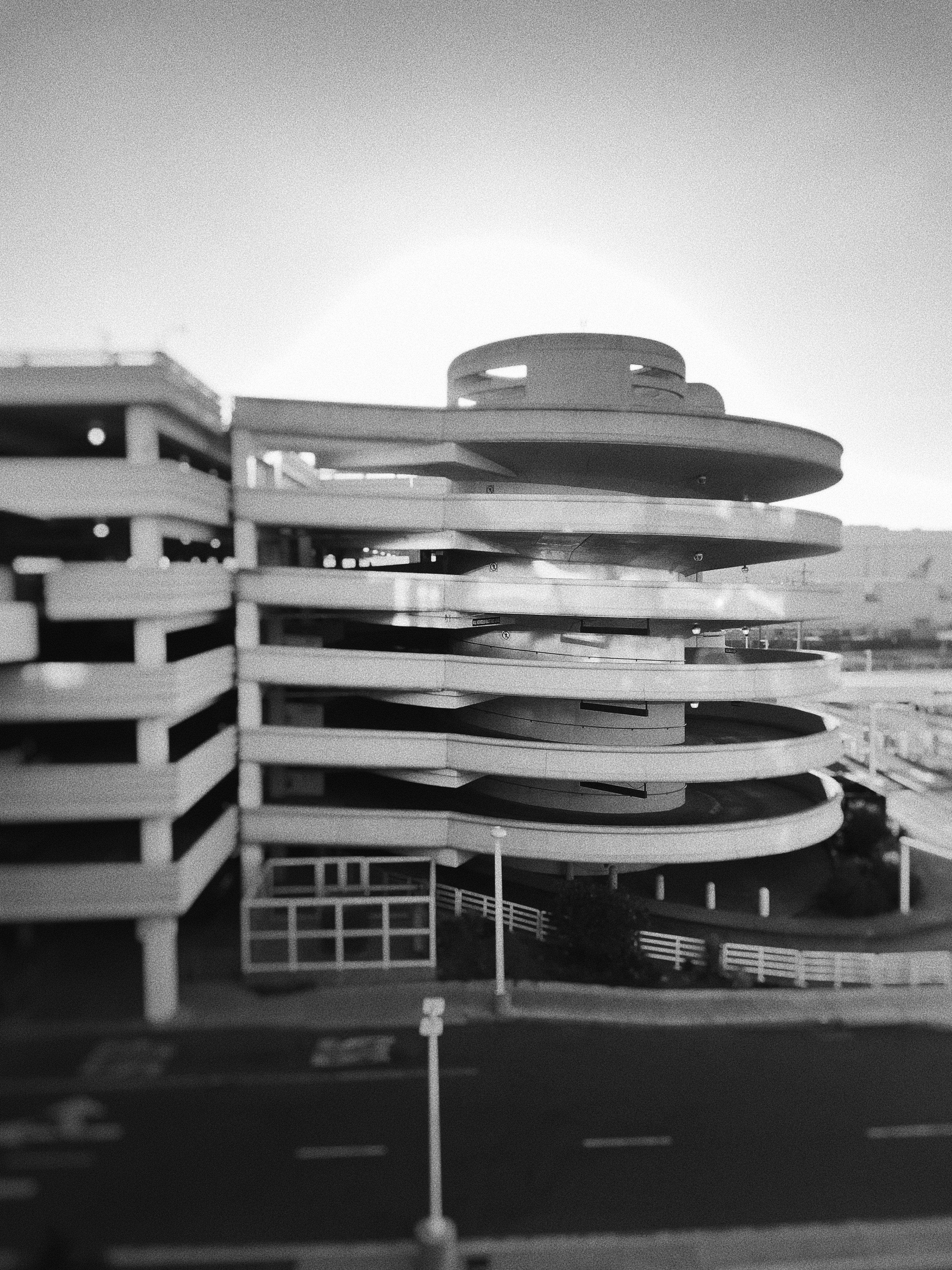 Abstract view of a multi-level parking structure showcasing its unique architectural curves and lines in monochrome.