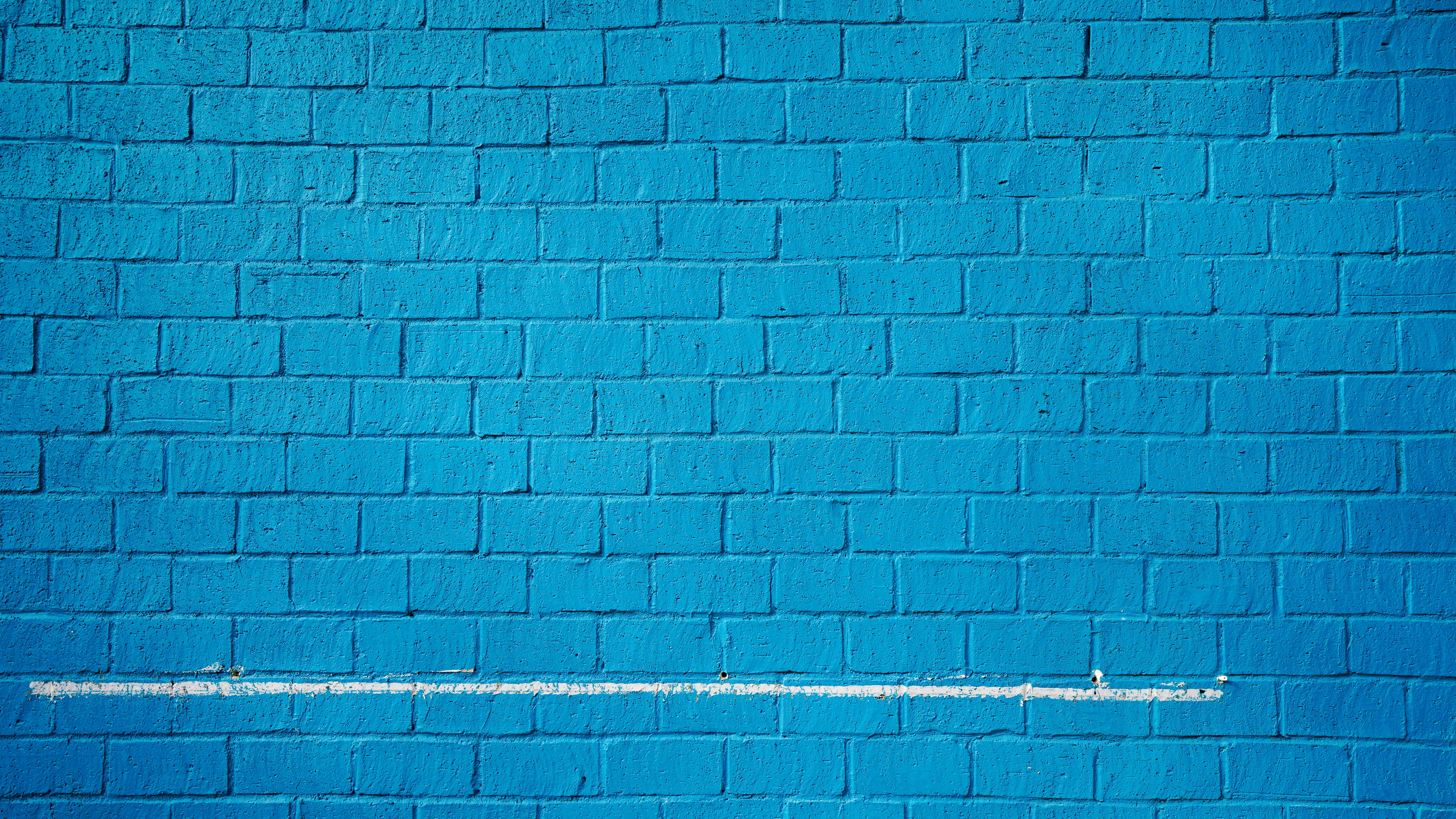 A blue brick wall with a white line painted on it photo – Free Wall ...