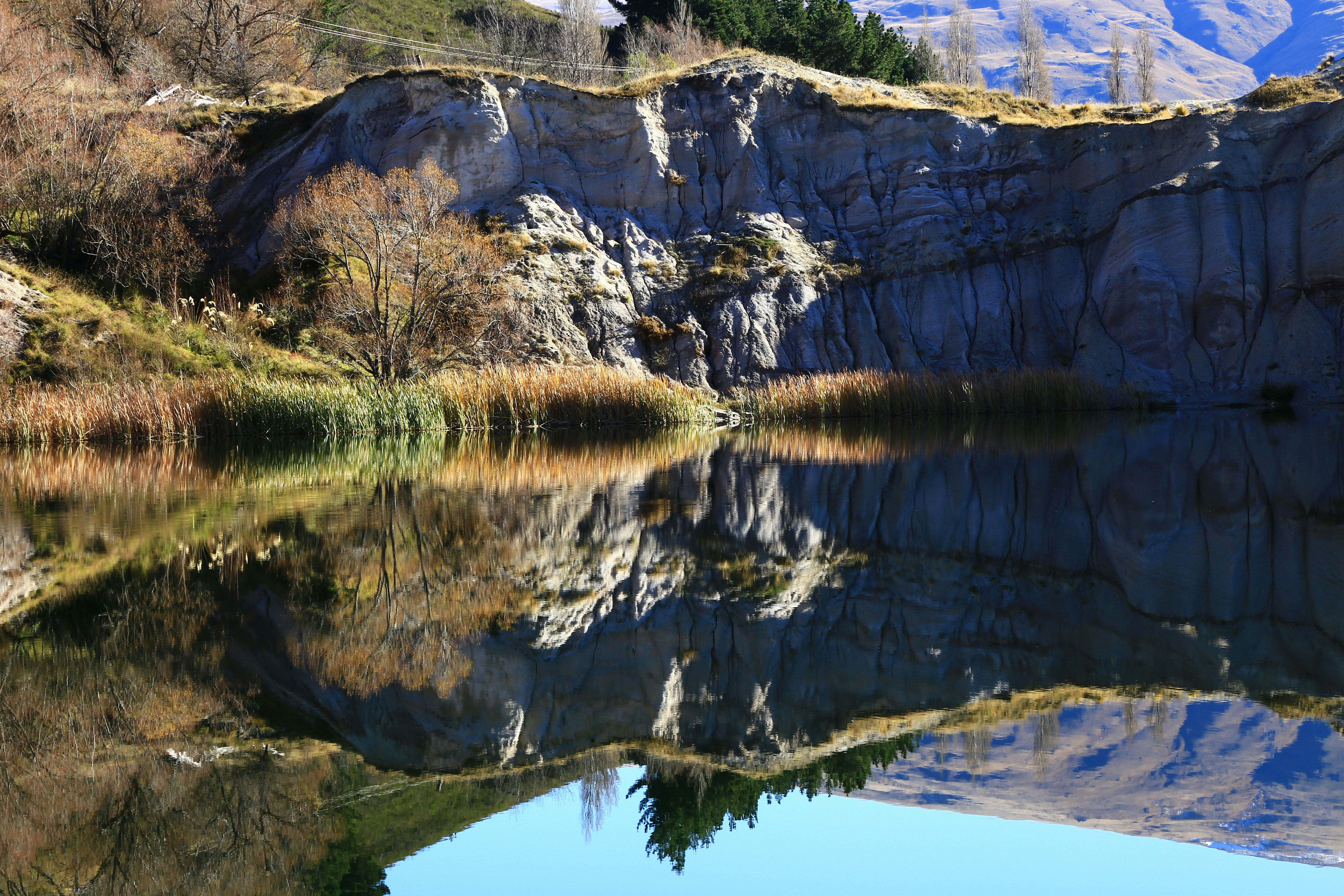 Mirror of Stone: Cliffside Portrait in a Glassy Lake