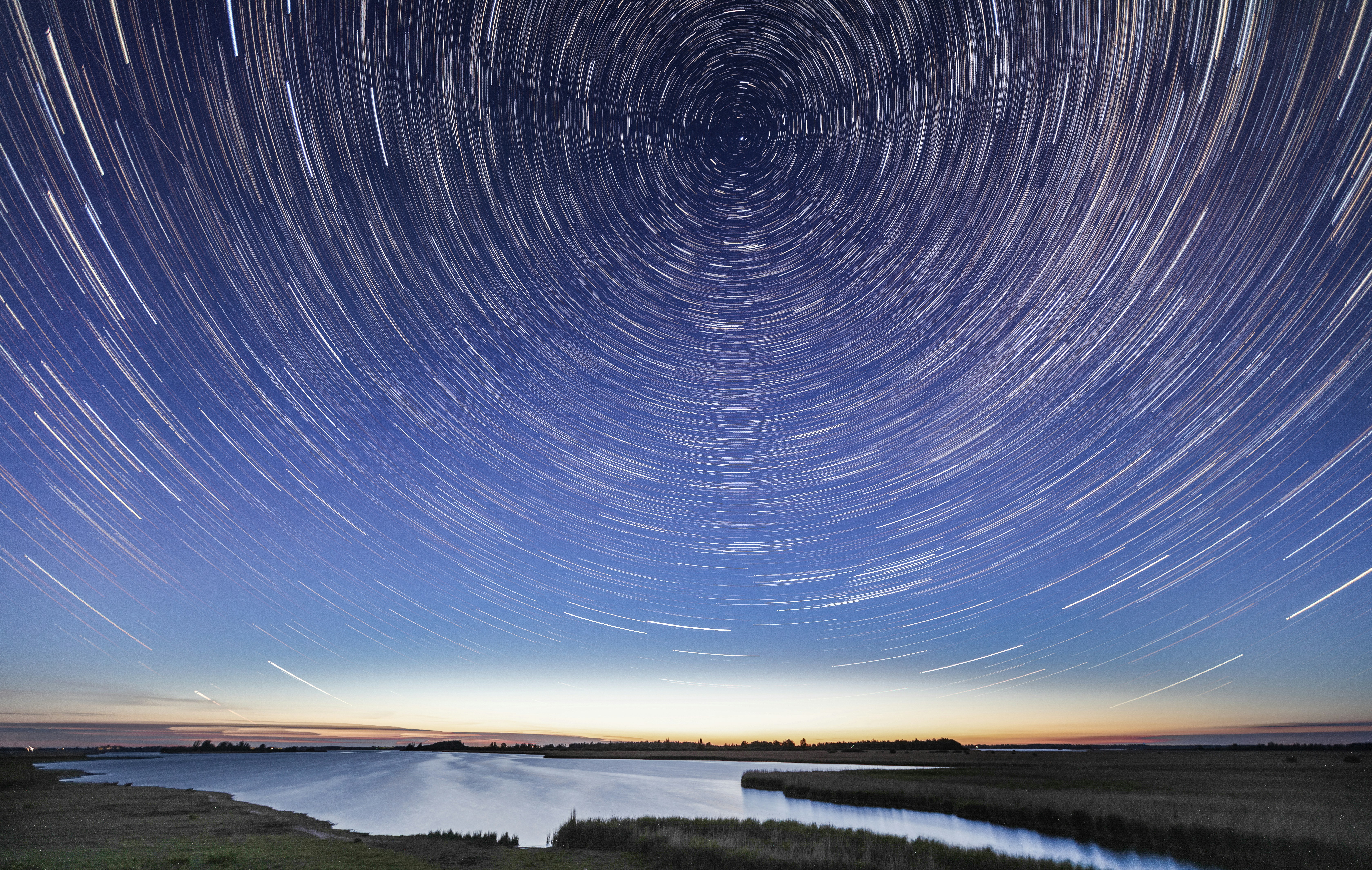 Time lapse photography of stars above body of water during night time ...
