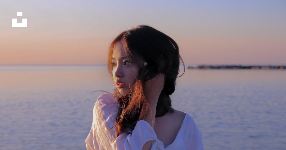 낮 동안 물가에 서 있는 흰색 긴팔 셔츠를 입은 여자 사진 Unsplash의 무료 바다 이미지