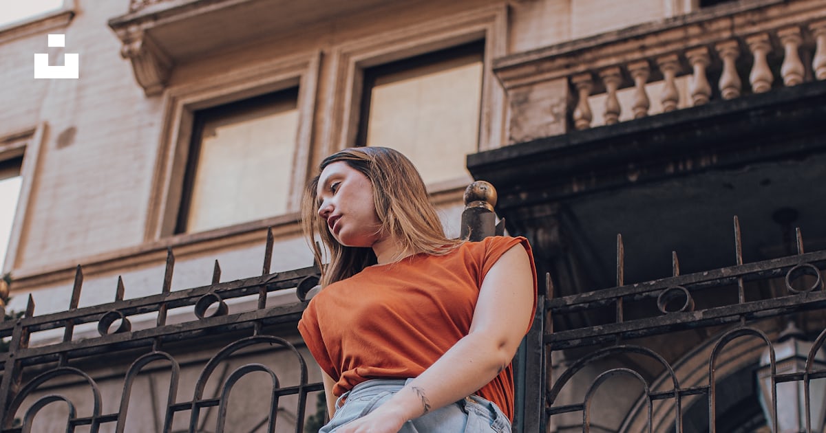 Mujer Con Camiseta Naranja Y Jeans De Mezclilla Azul Sentada En Una