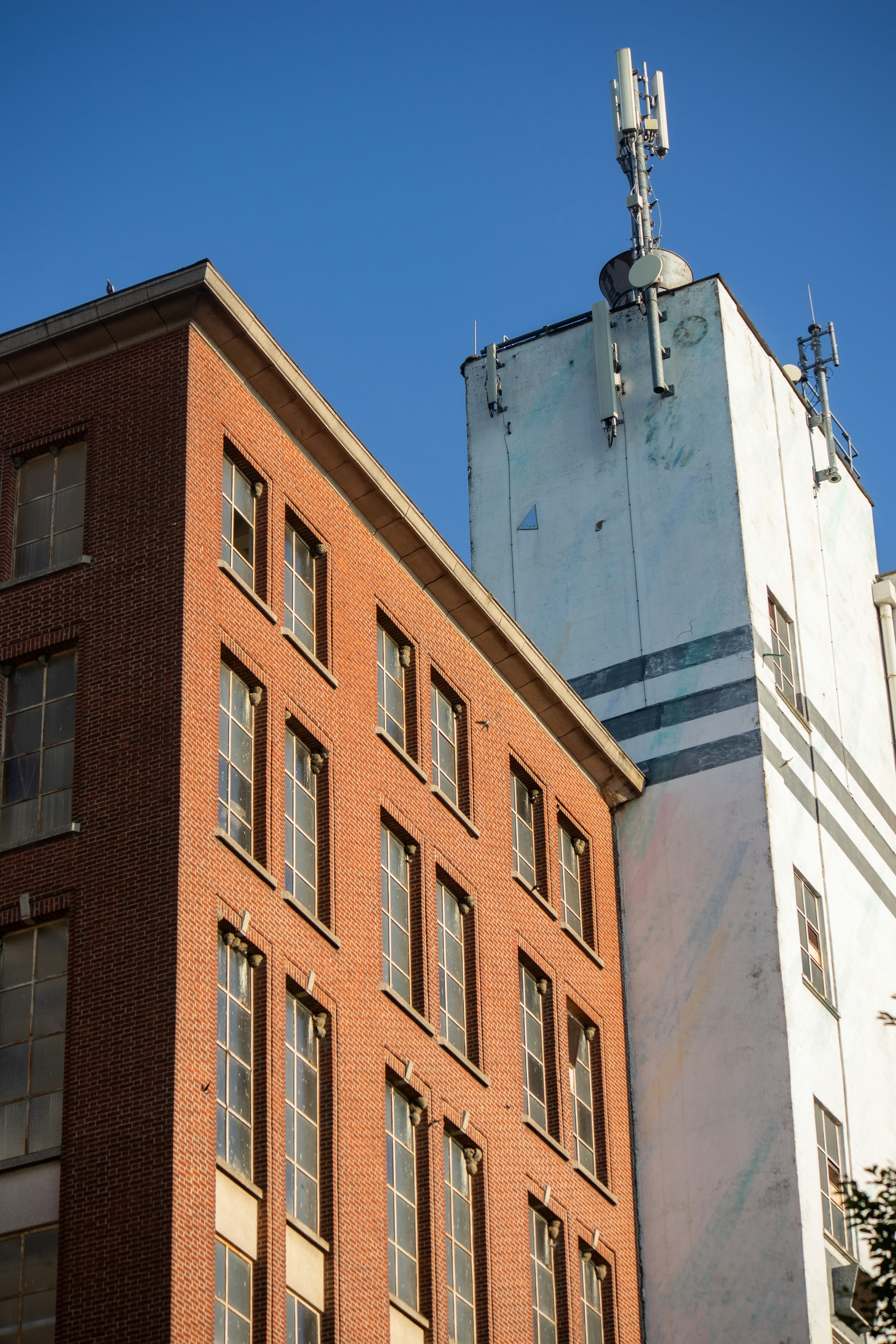 Un grand bâtiment en briques à côté d’un grand bâtiment en briques ...