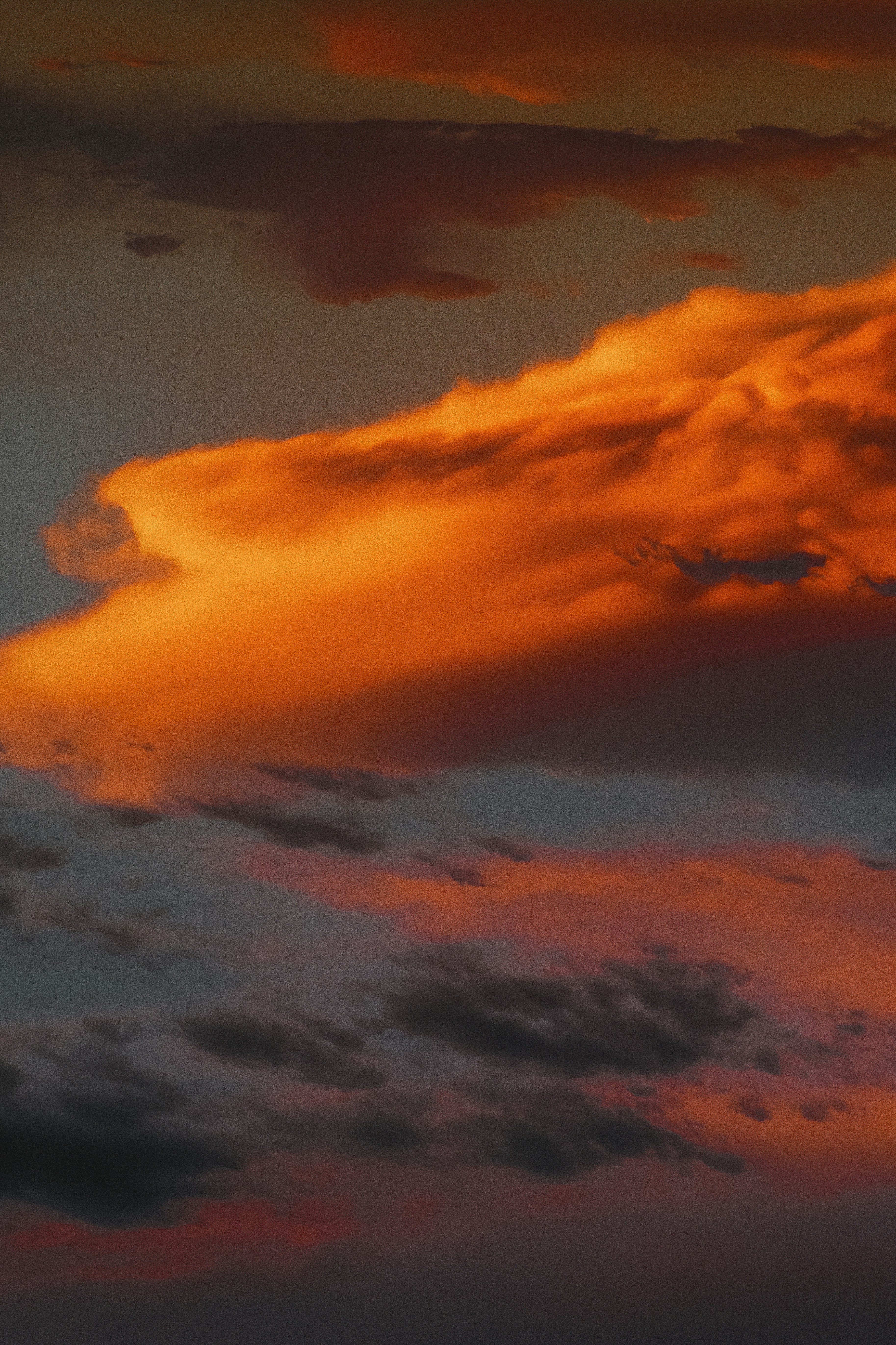 Vibrant clouds painted in shades of orange and purple during sunset, creating a dramatic celestial canvas.