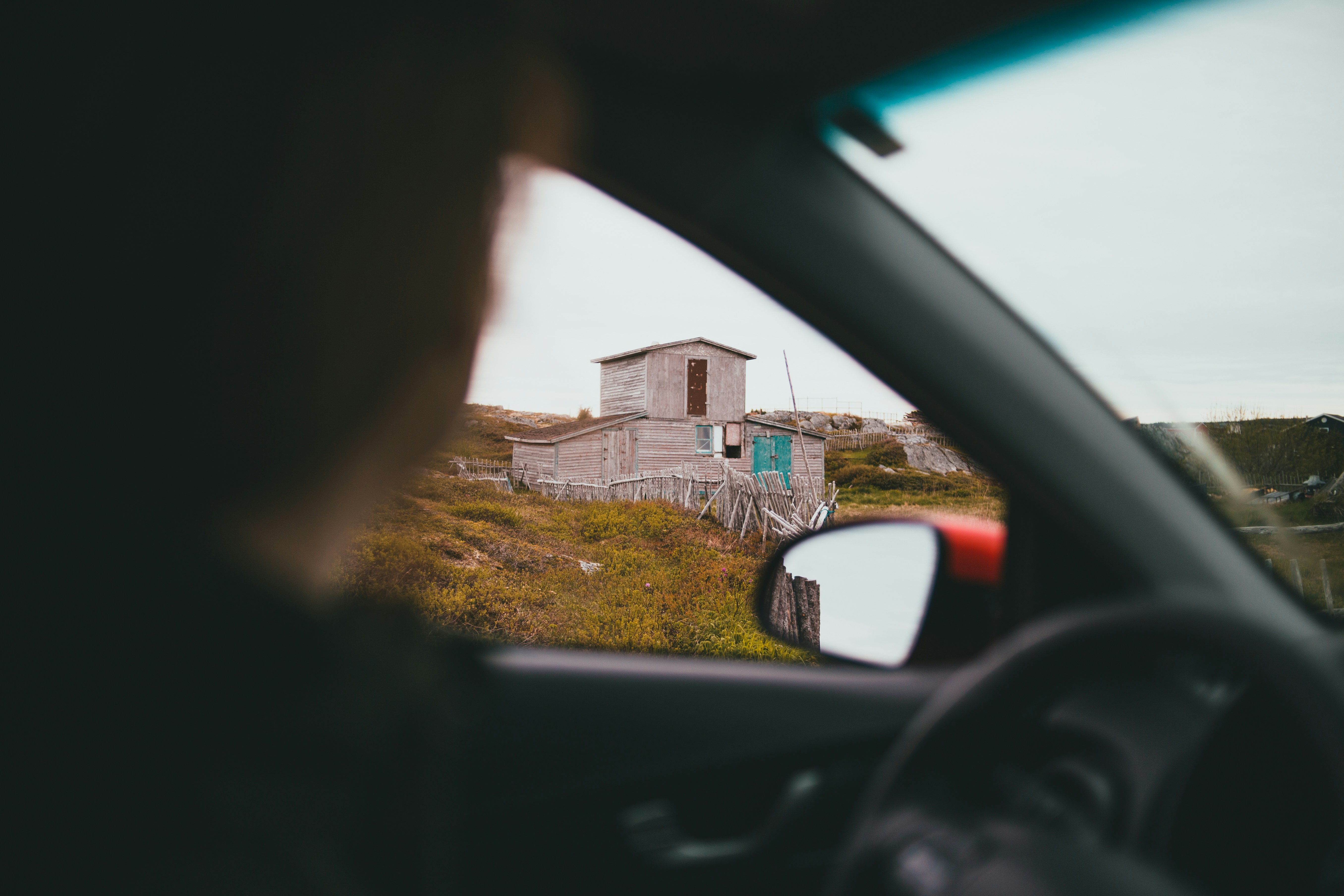 A person looking out of a car window at a house photo – Free Mirror ...