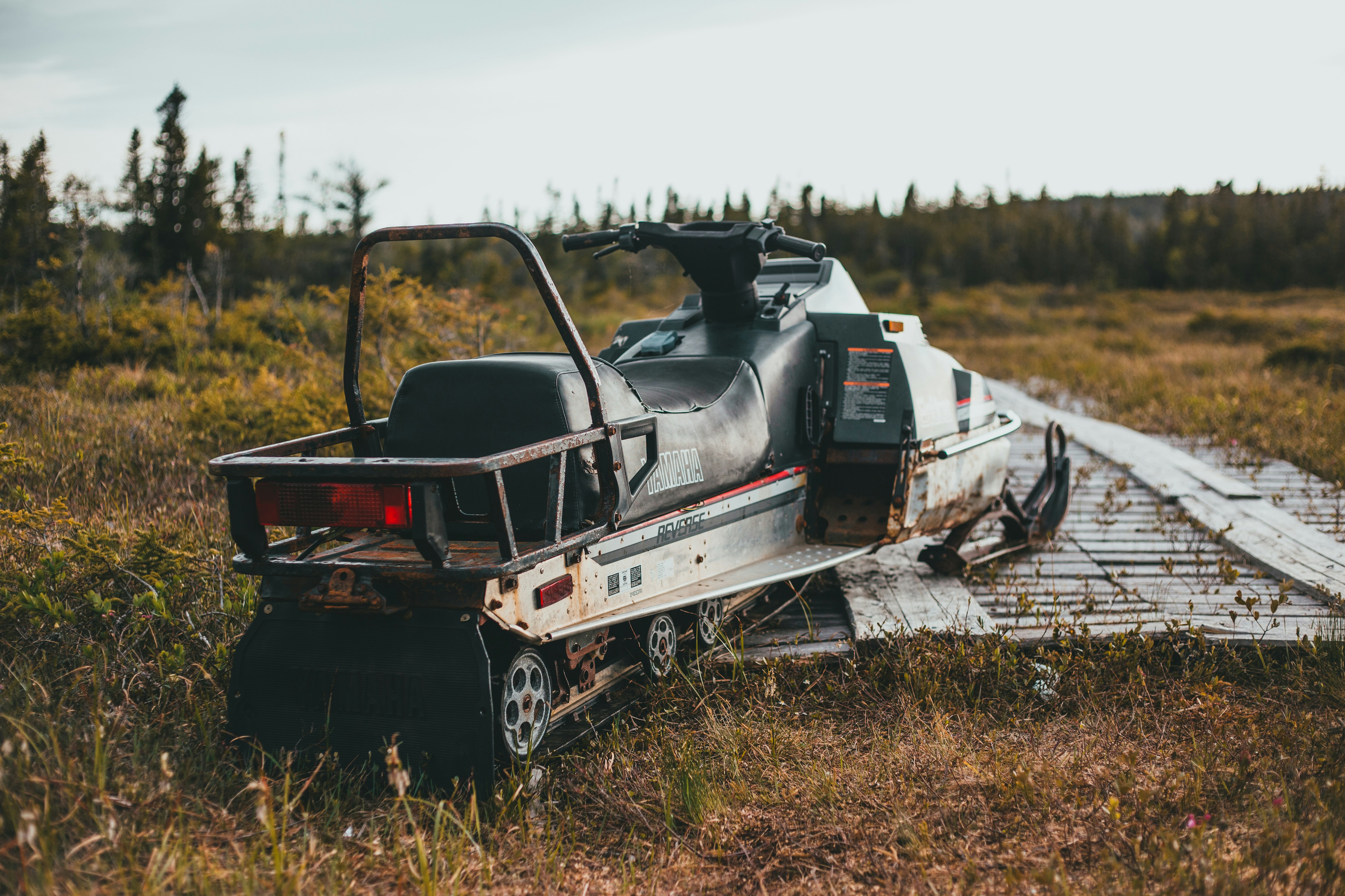 Forgotten Snowmobile on a Weathered Boardwalk Through a Quiet Marshland