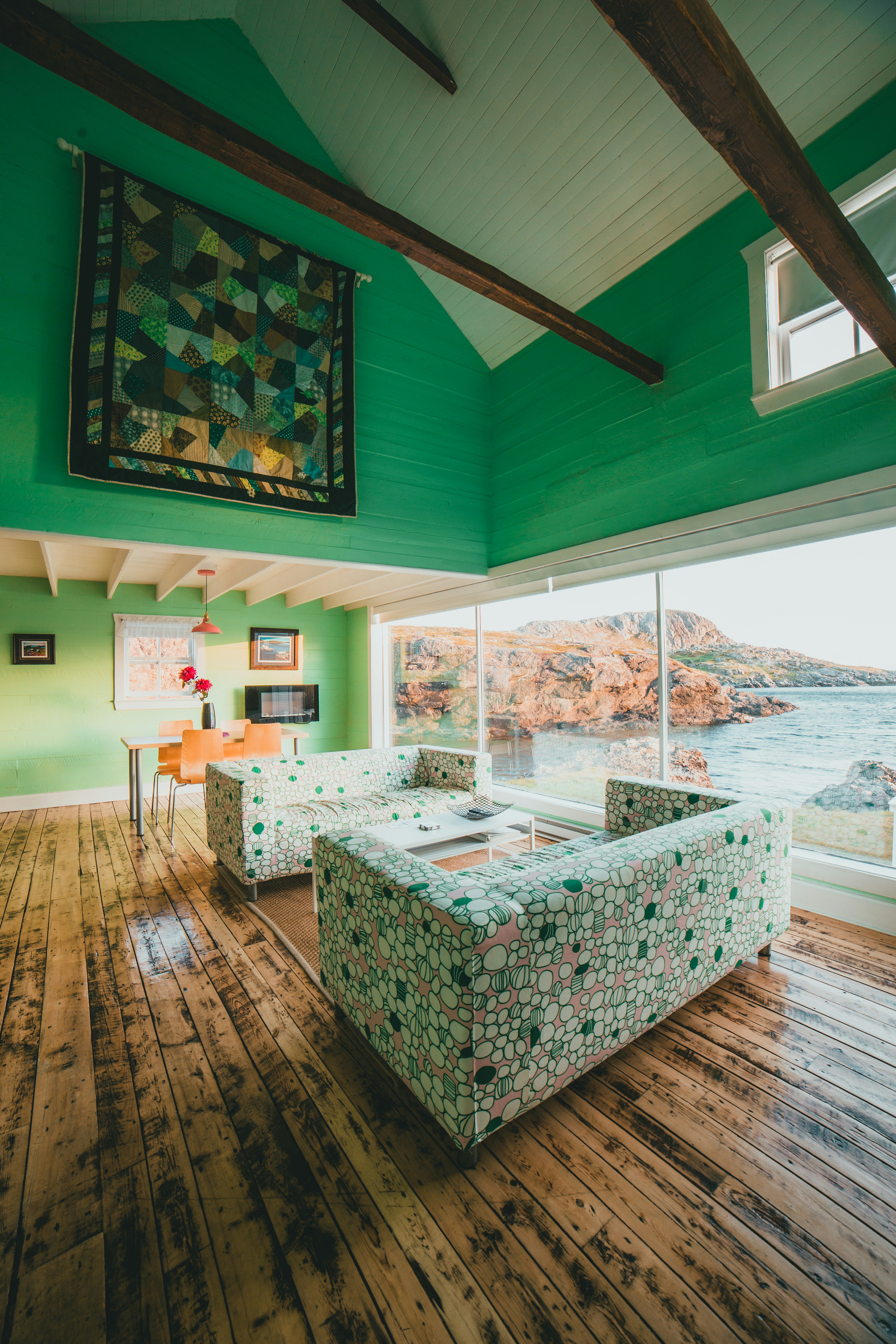 Verdant Coastal Living Room: Patchwork Seating Meets a Sea-Wide View