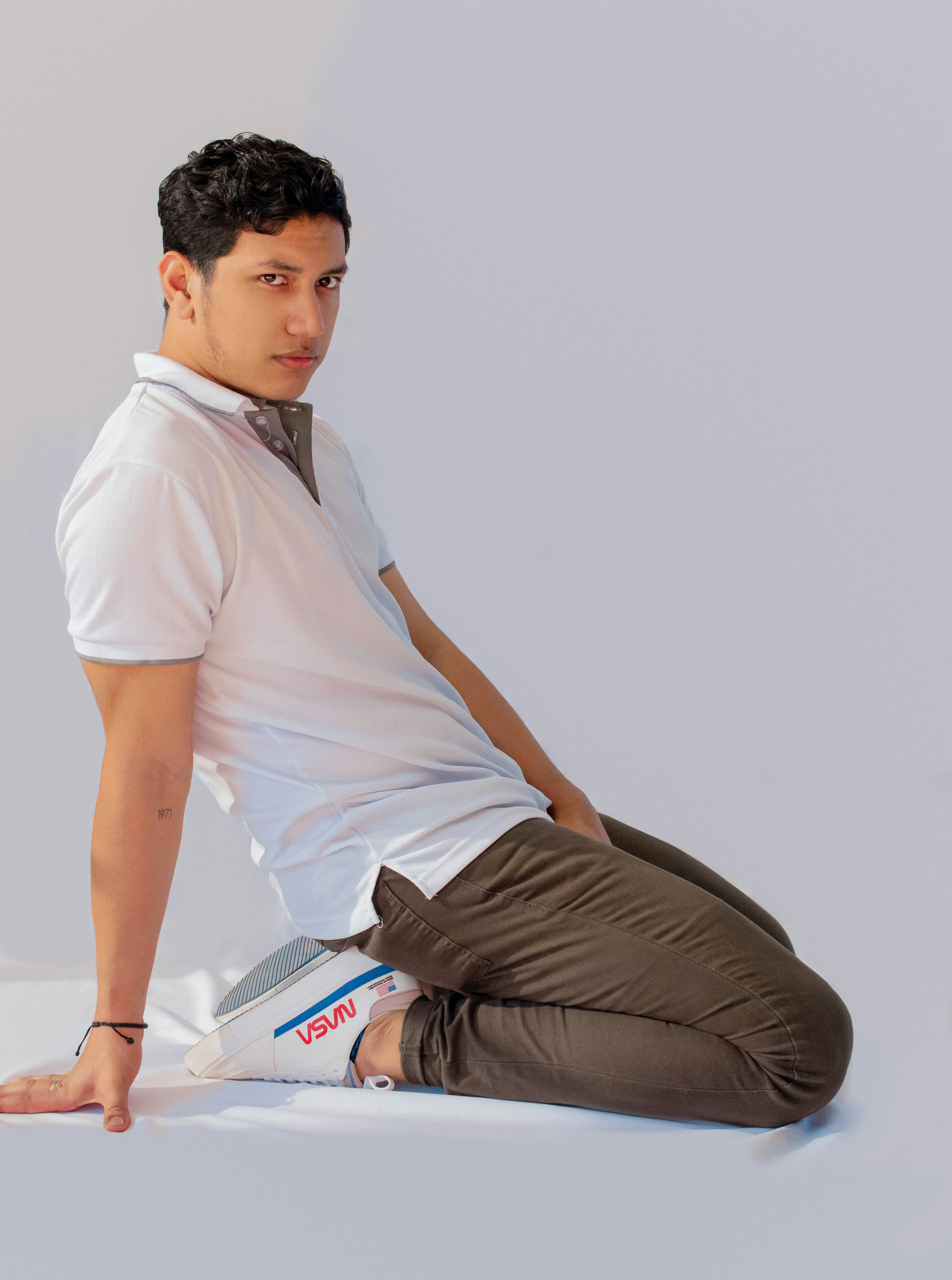 Quiet Confidence in Studio Light: Portrait of a Man in White Polo