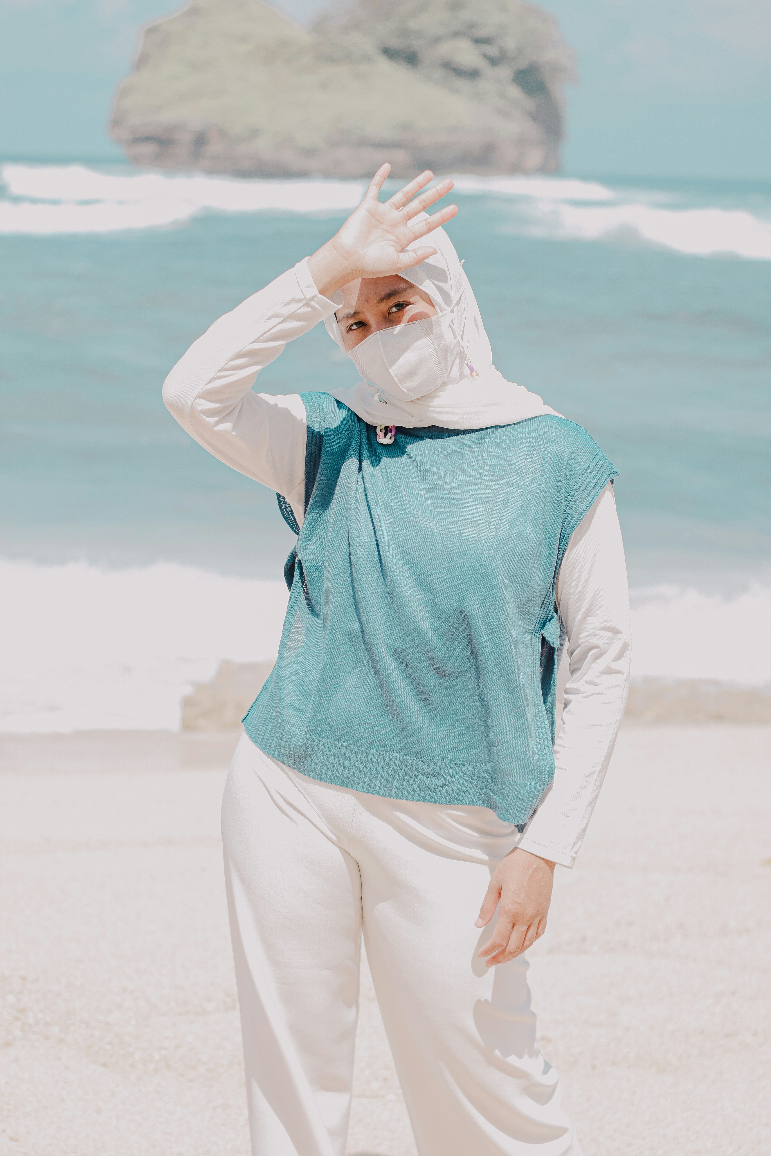 a woman wearing a face mask on the beach