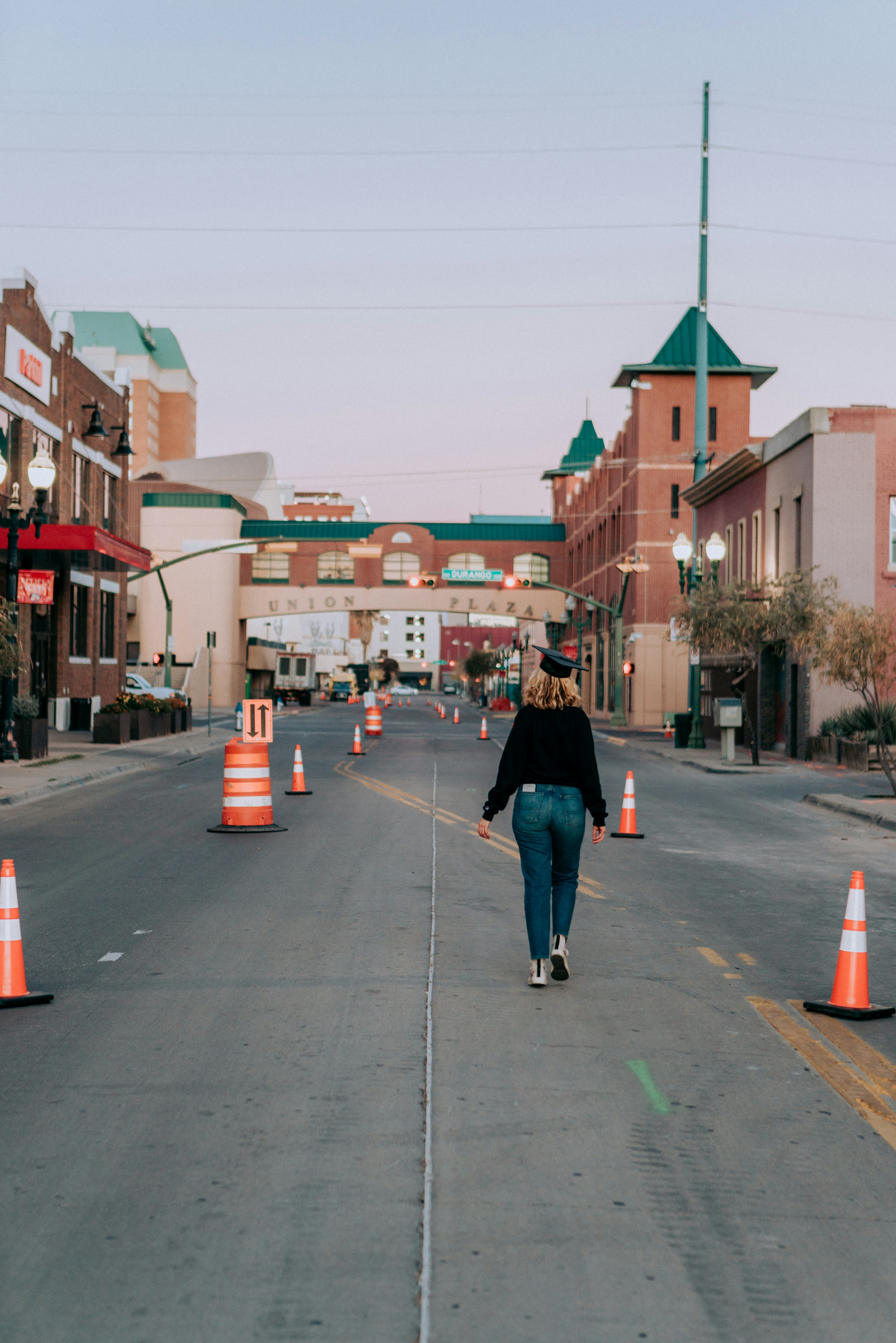 Crossing the Street: A Solo Figure Walks Toward the City Gate
