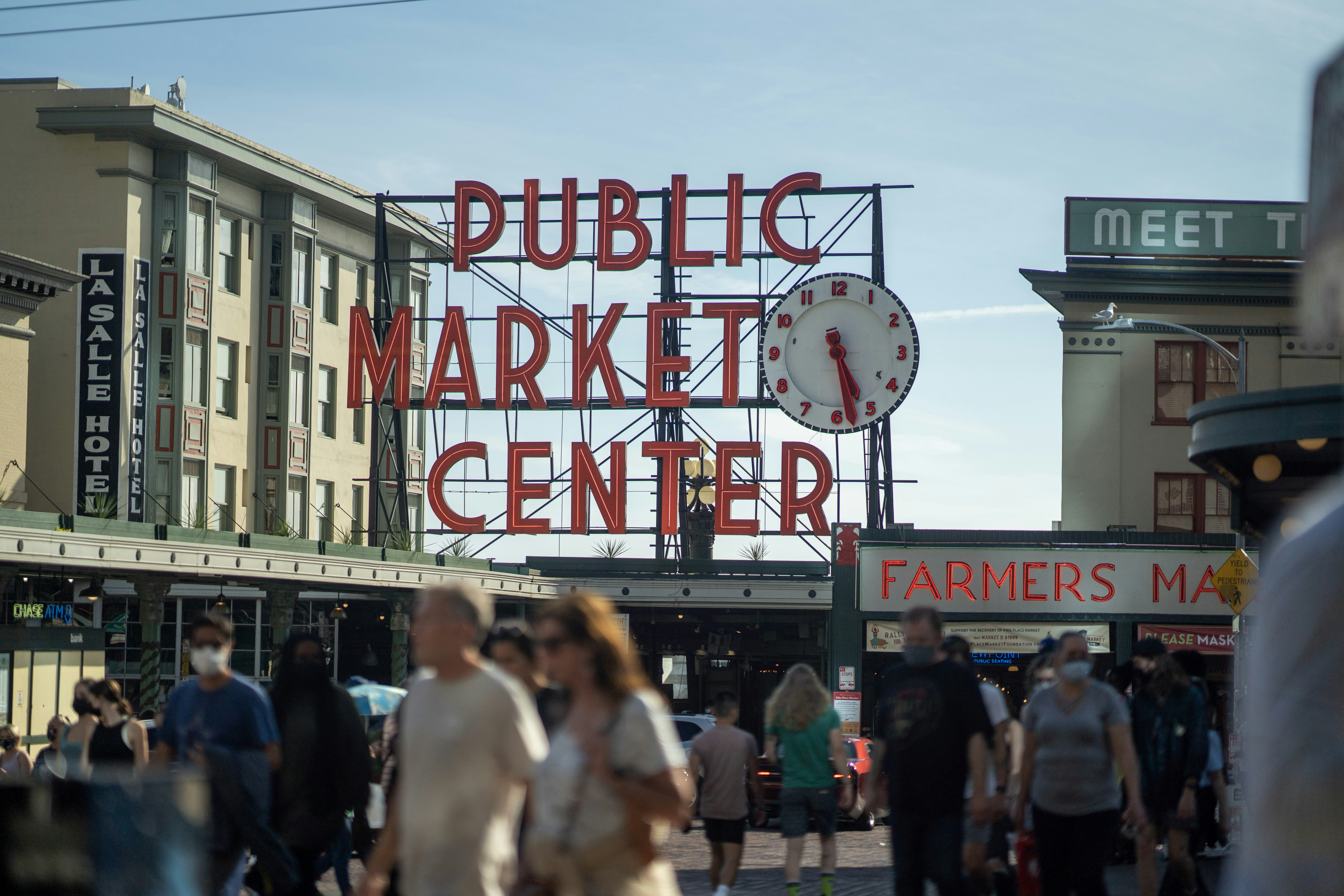 A crowd of people walking around a public market center photo – Free ...