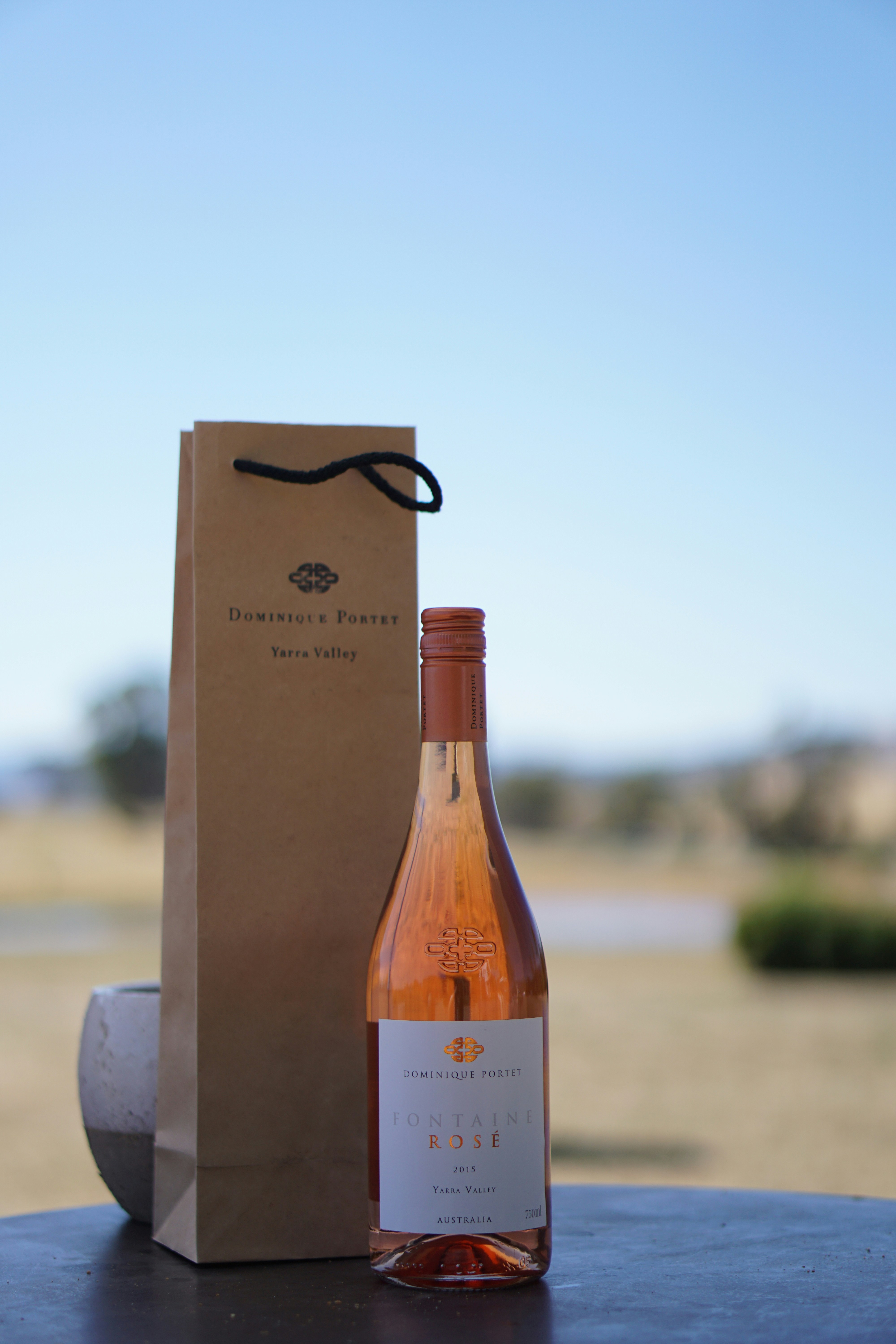 Rosé in Focus: A Quiet Still Life with Bag and Bottle Outdoors