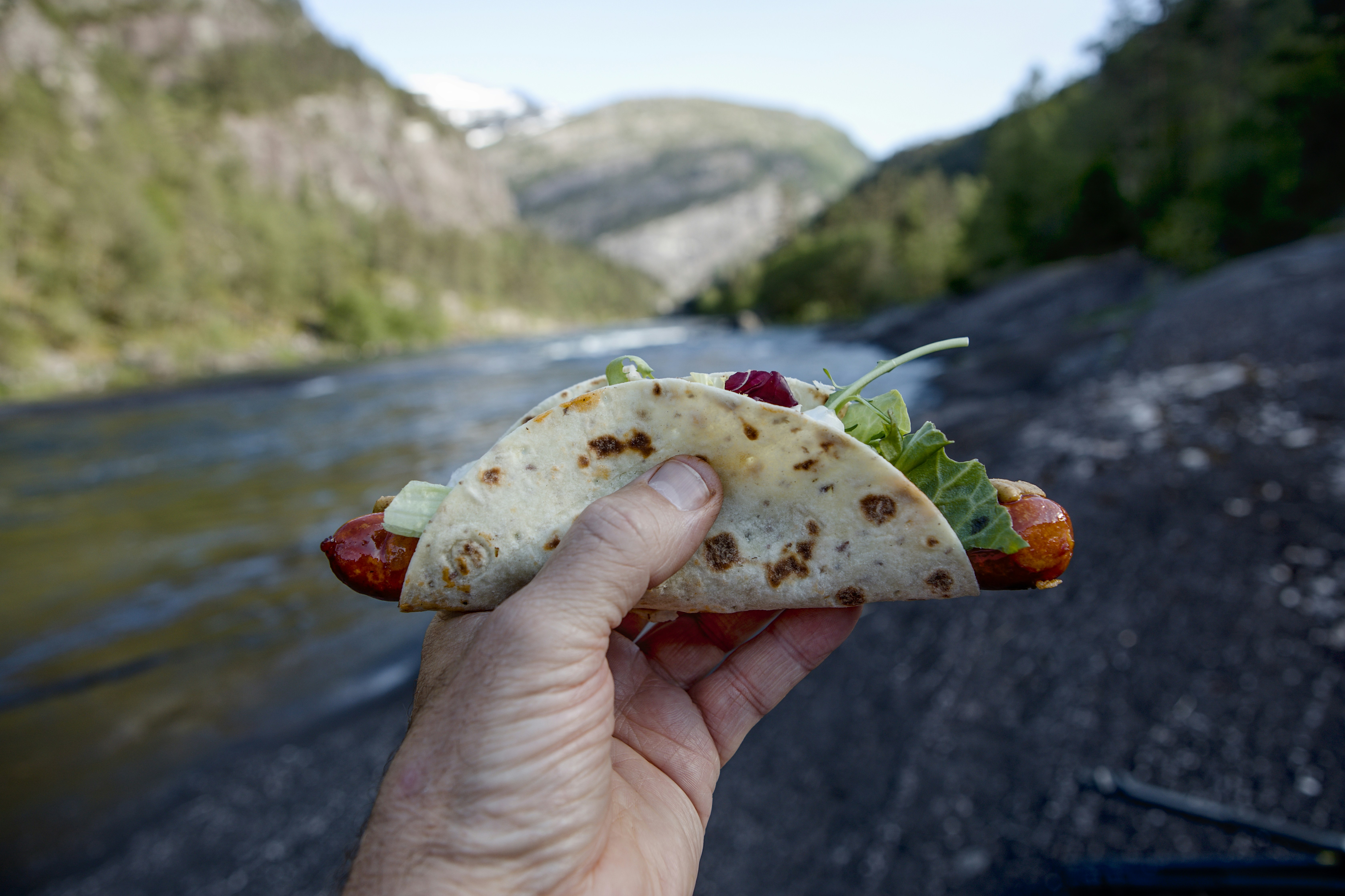 Hands-On Taco in a River Canyon: A Snack Break Amid Broad Scenery