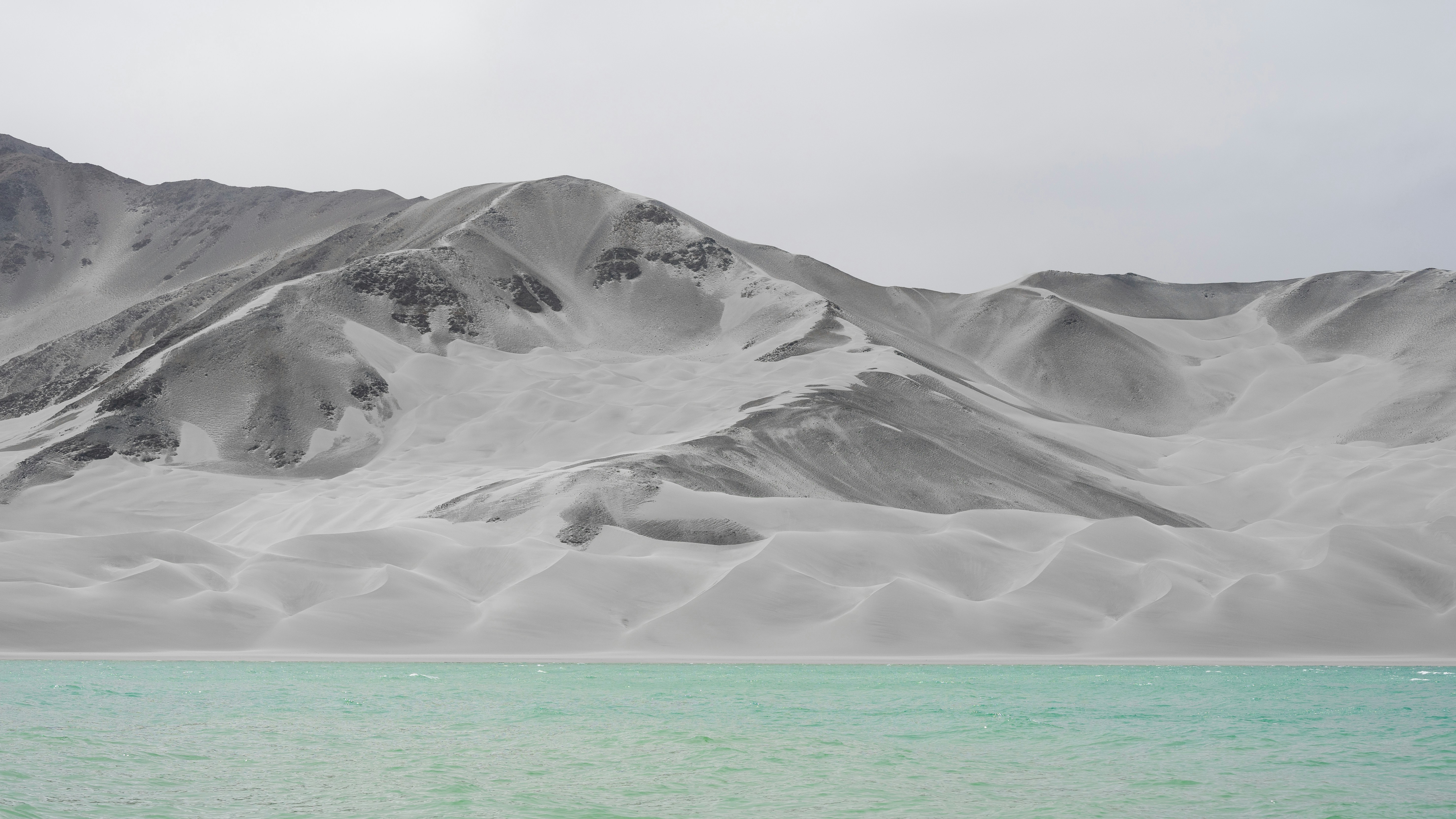 Turquoise Tide Against Ashen Dunes