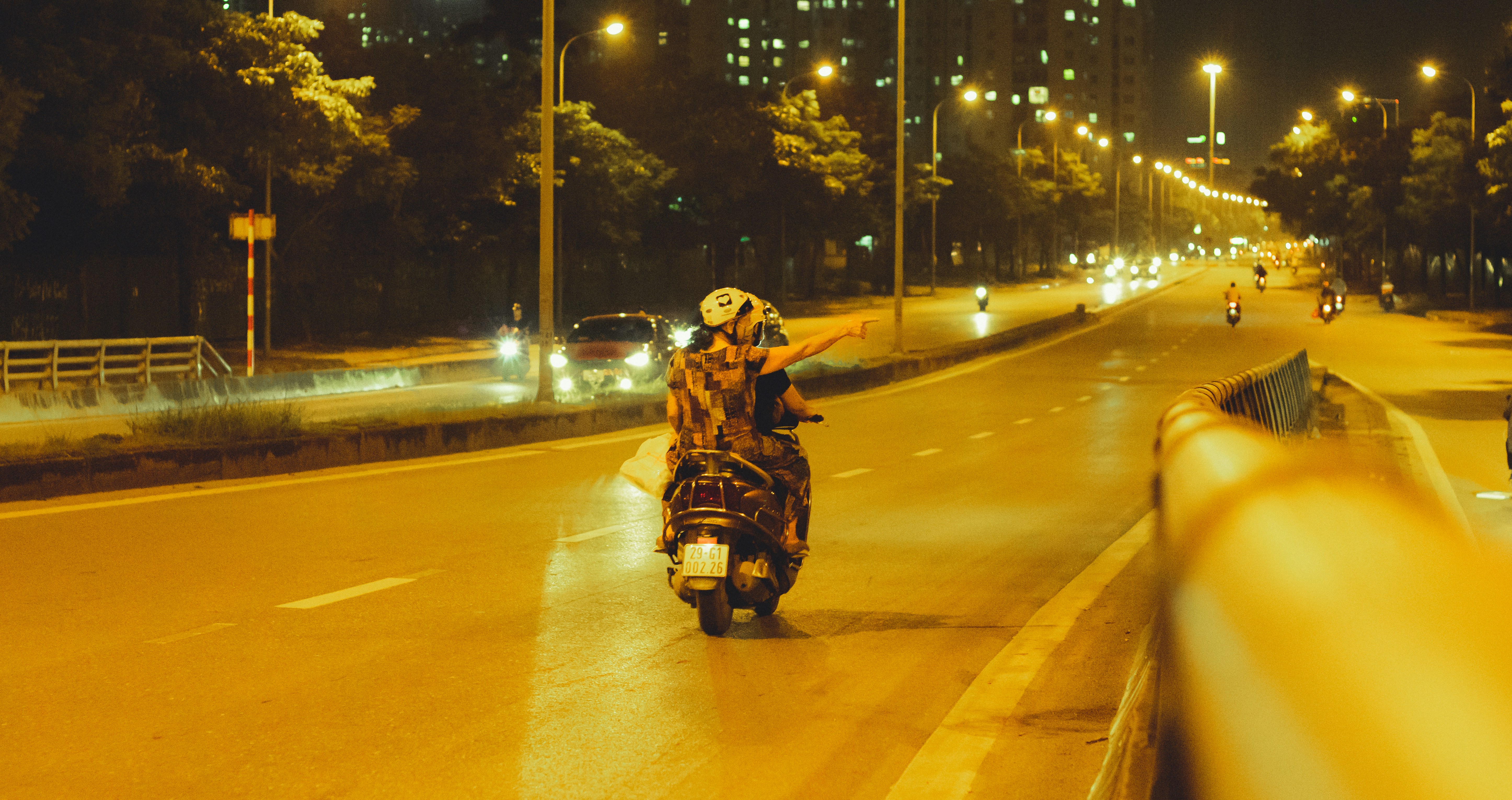 Un Hombre Conduciendo Una Motocicleta Por Una Calle Por La Noche Foto