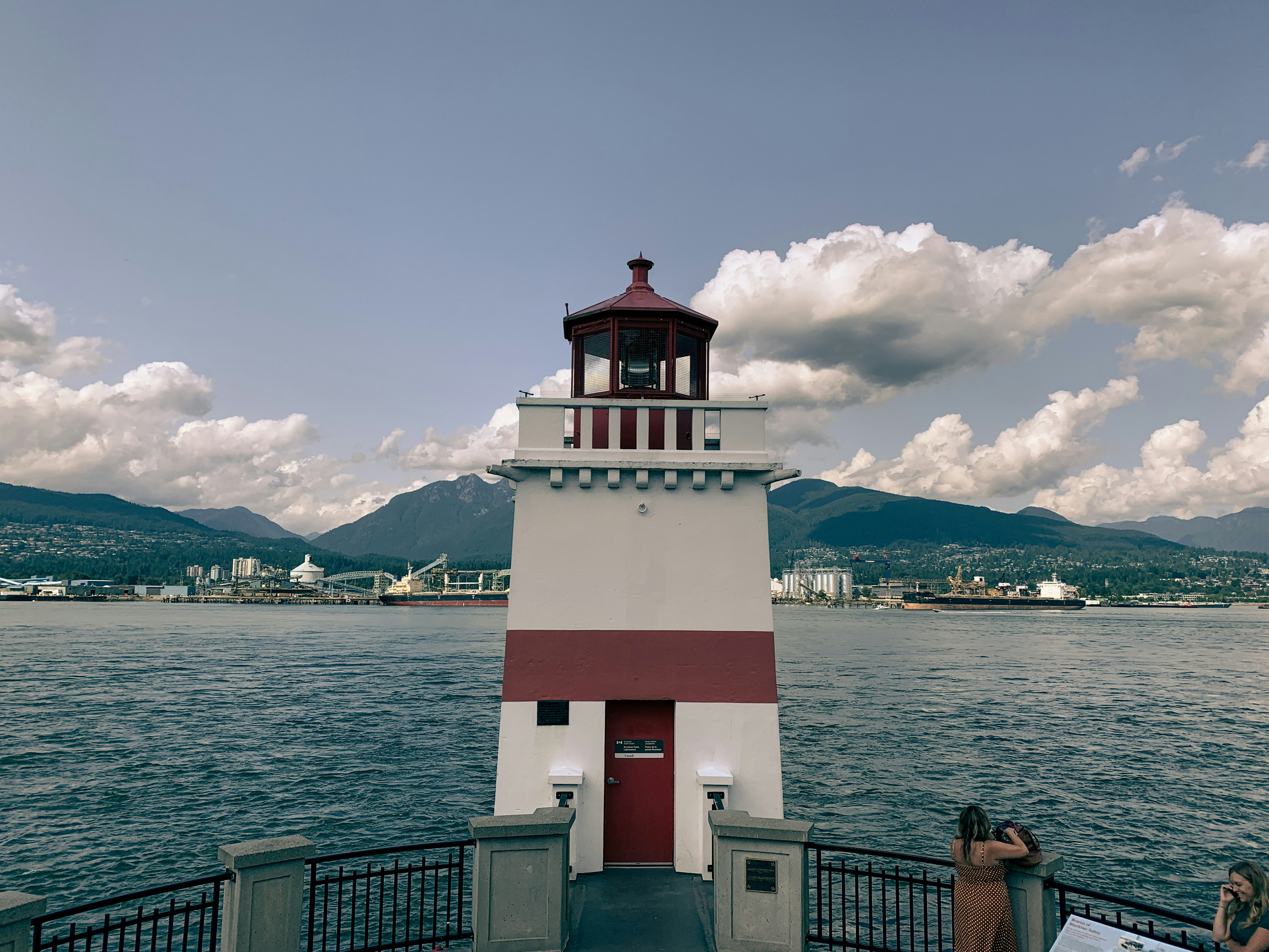 white and red concrete lighthouse near body of water during daytime