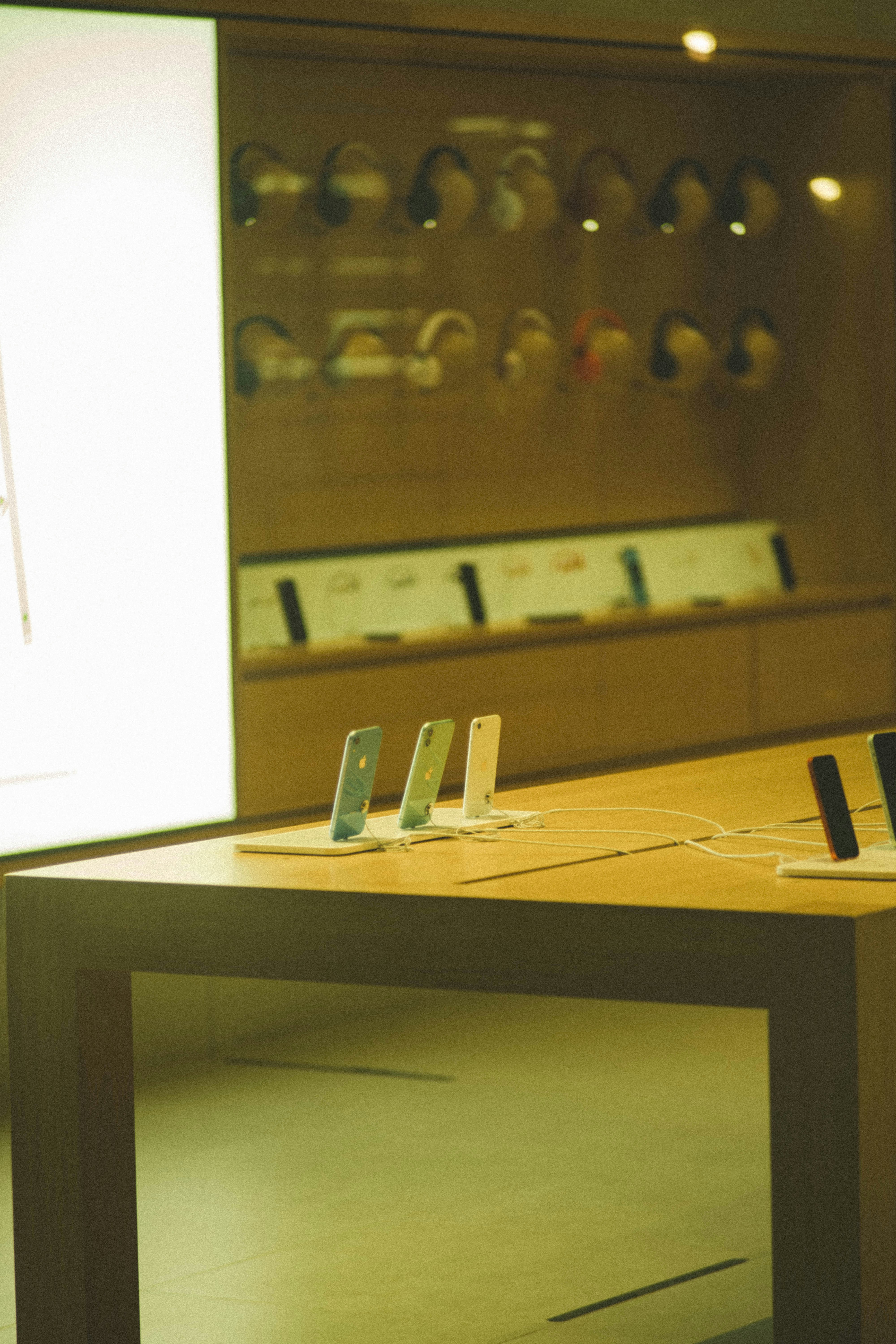 Tabletop Trio: A Quiet Smartphone Showcase Under Warm Store Lighting