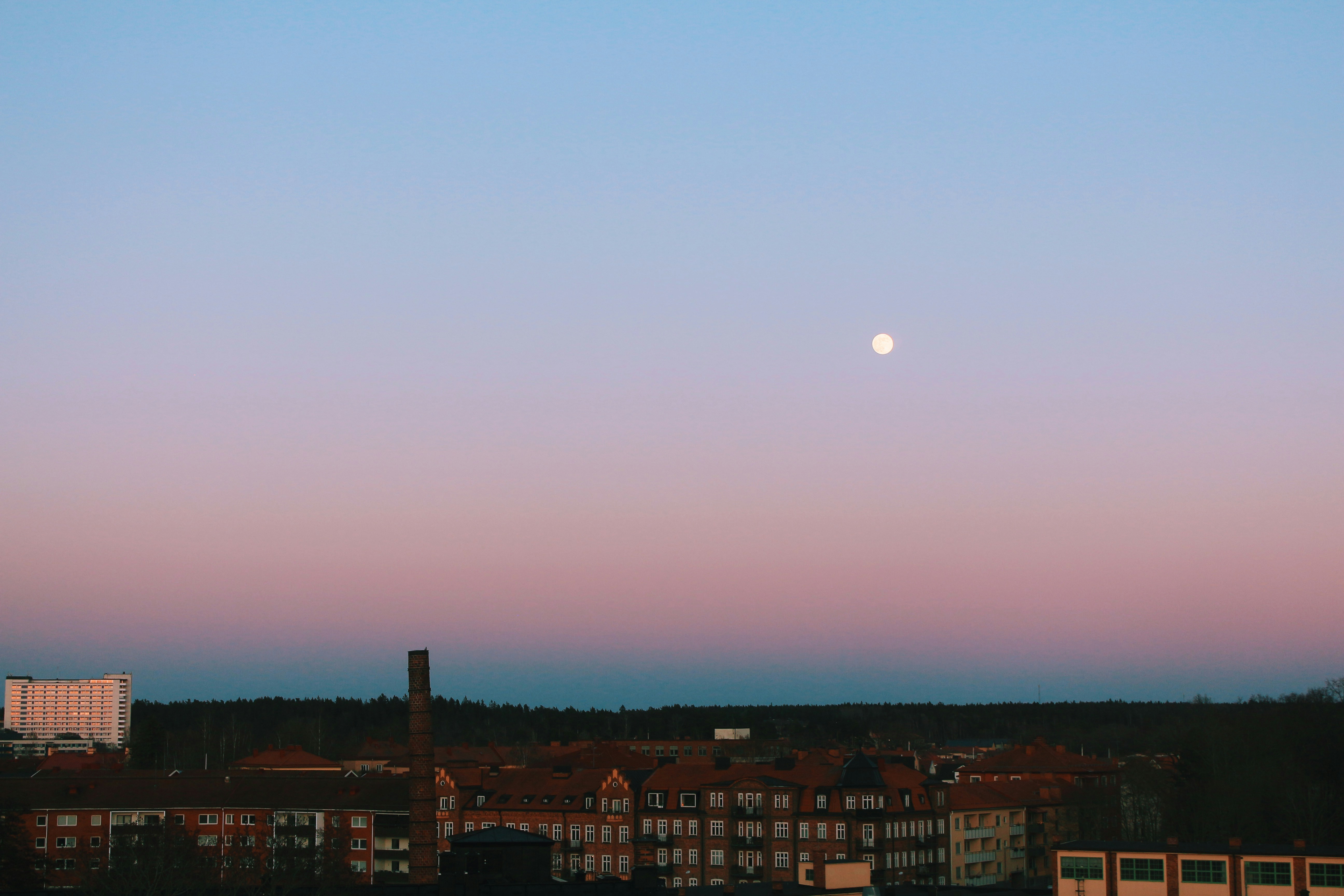 a full moon is seen in the sky over a city
