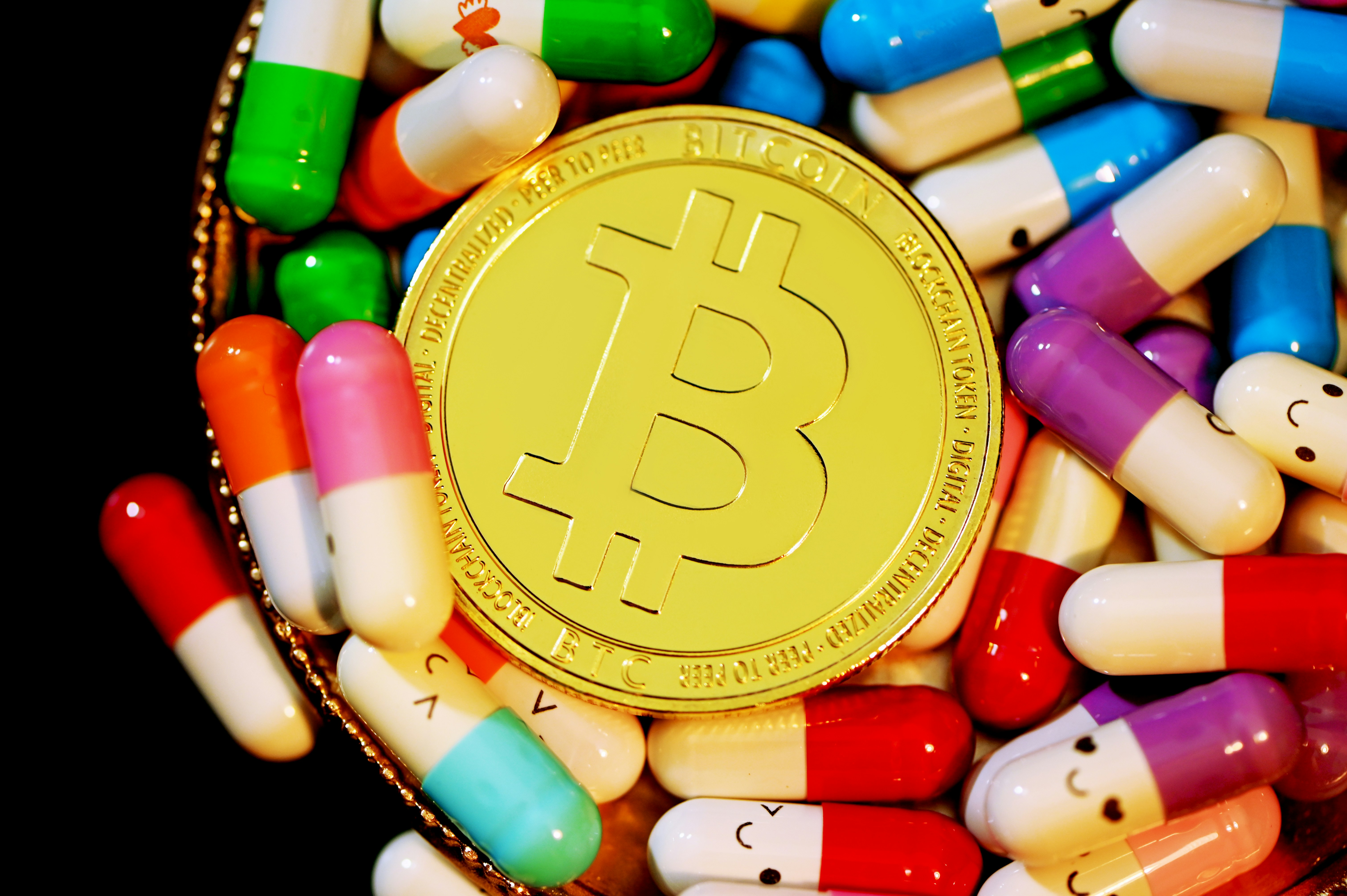 A bitcoin surrounded by pills in a bowl photo – Free Gold Image on Unsplash