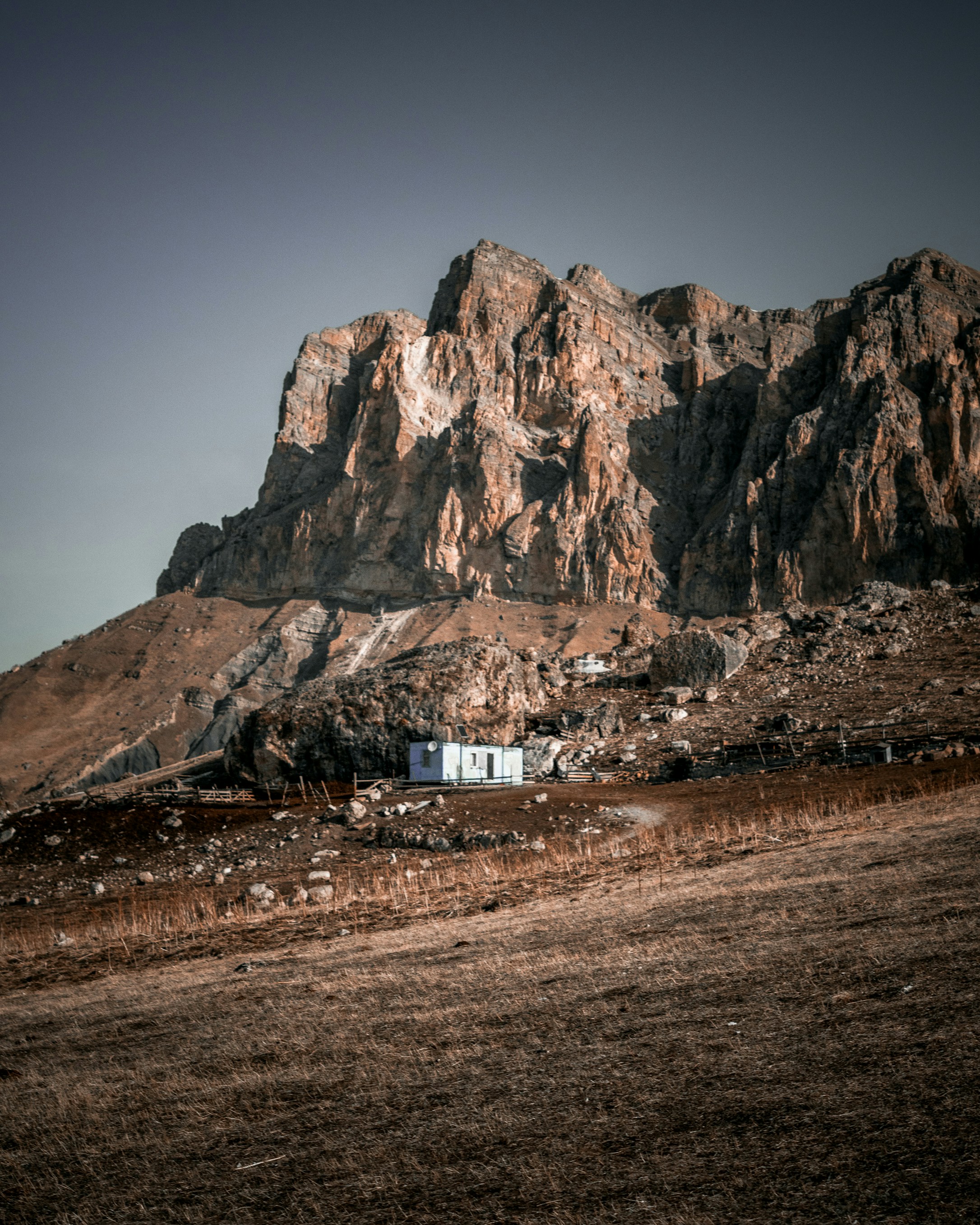 White Cabin Nestled at the Foot of Rugged Peaks