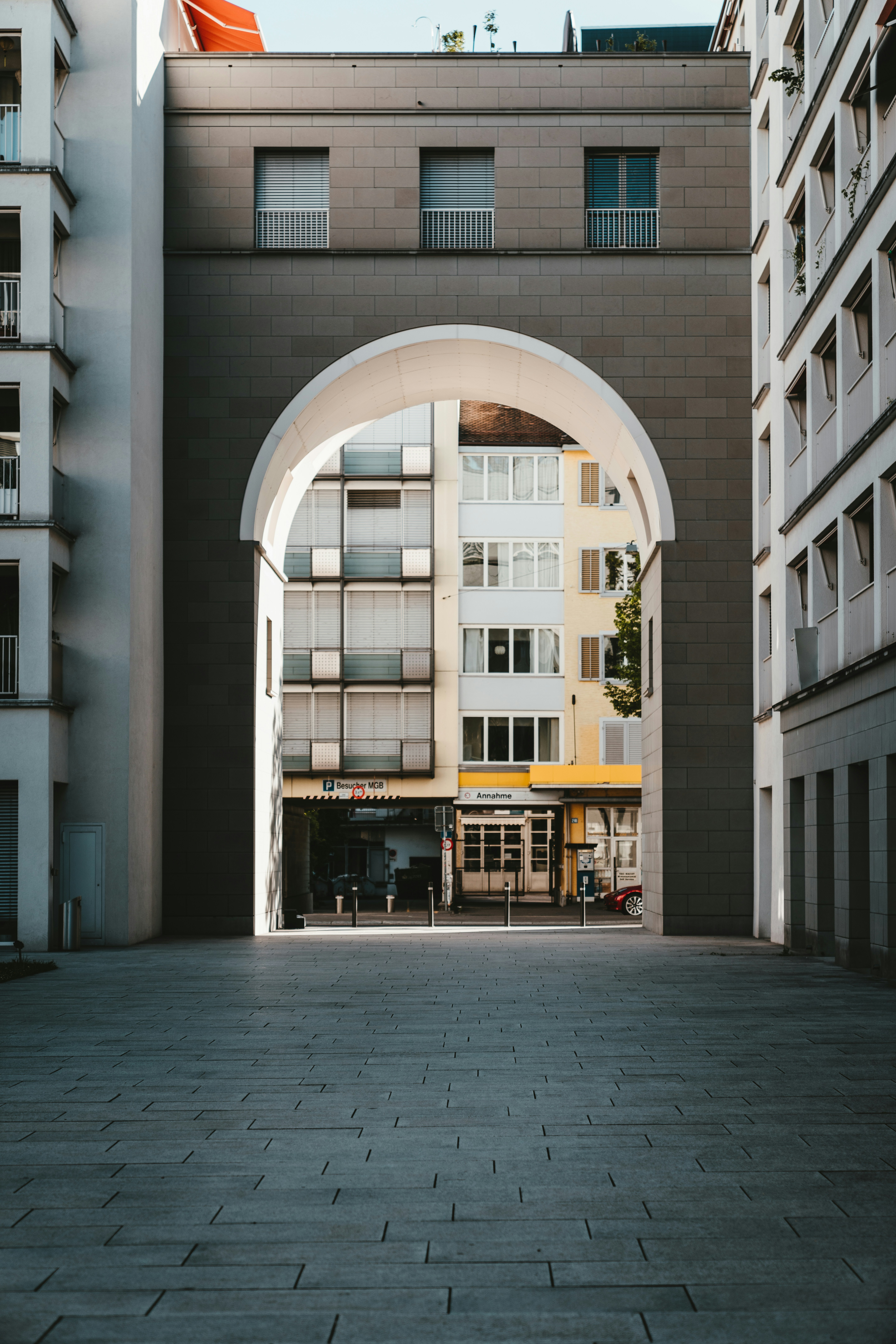 An arch in the middle of a courtyard between two buildings photo – Free ...