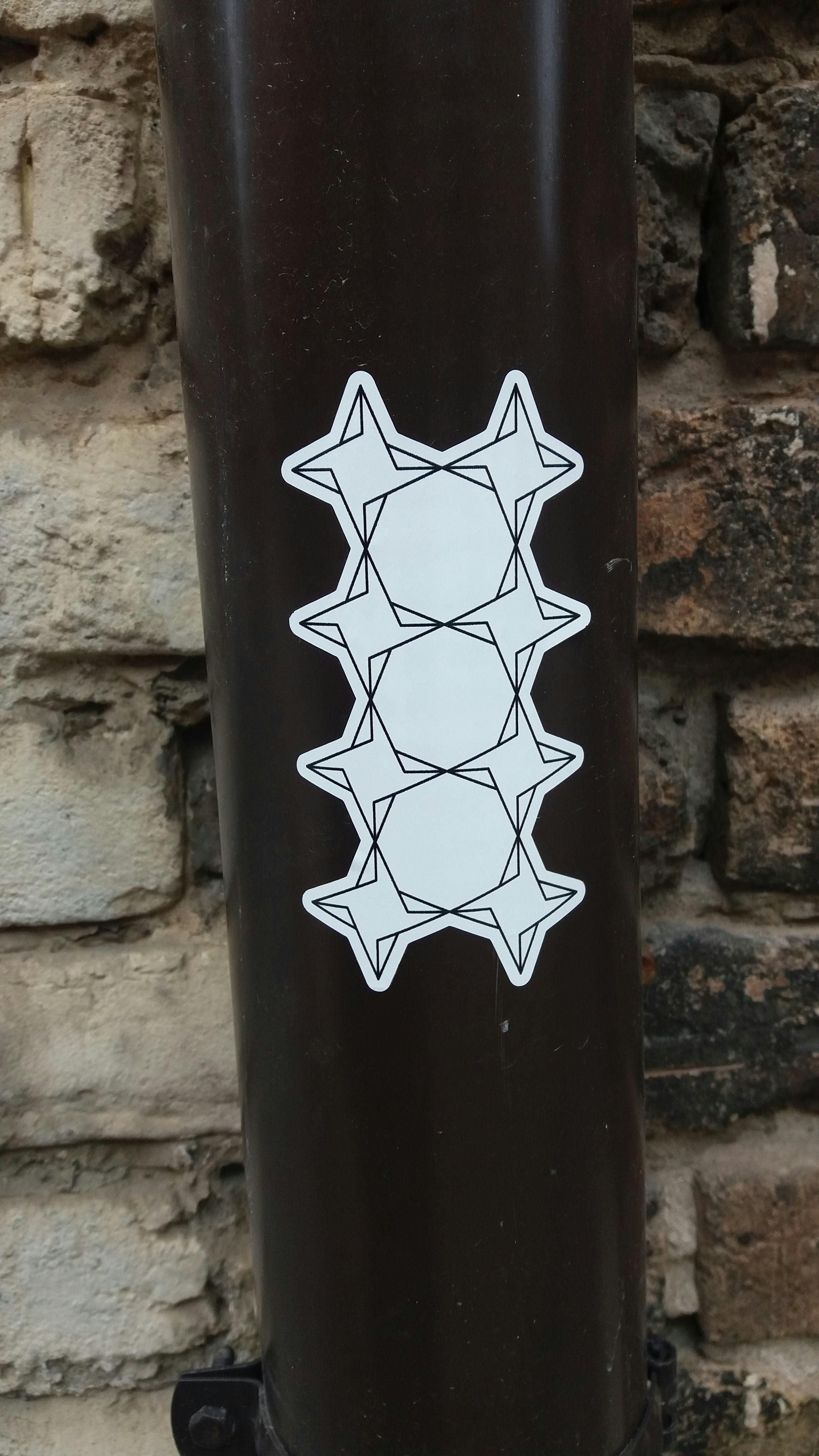 a black and white sticker on a brick wall